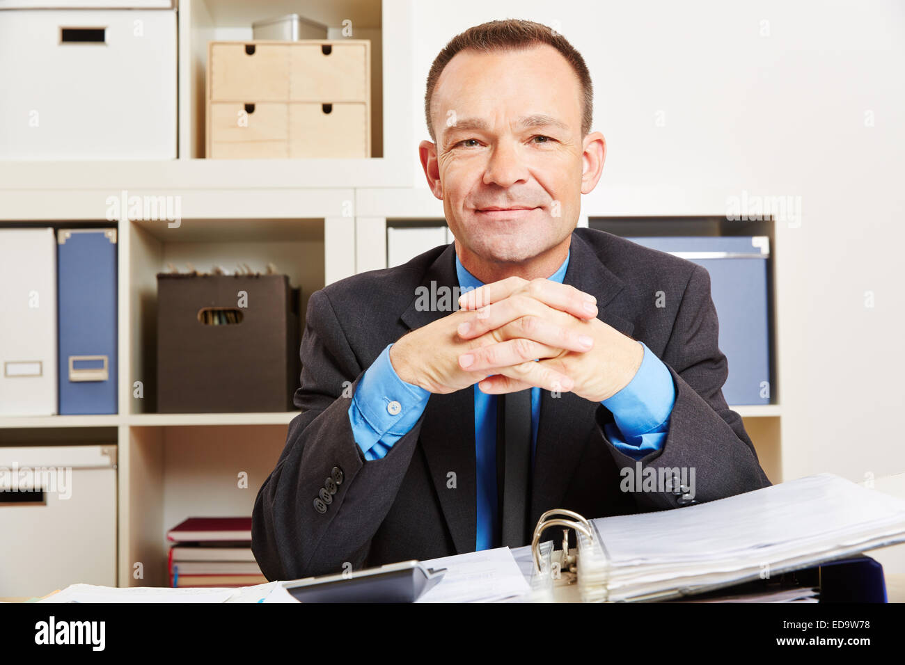 Accountant sitting at his desk in the office with files and a ...