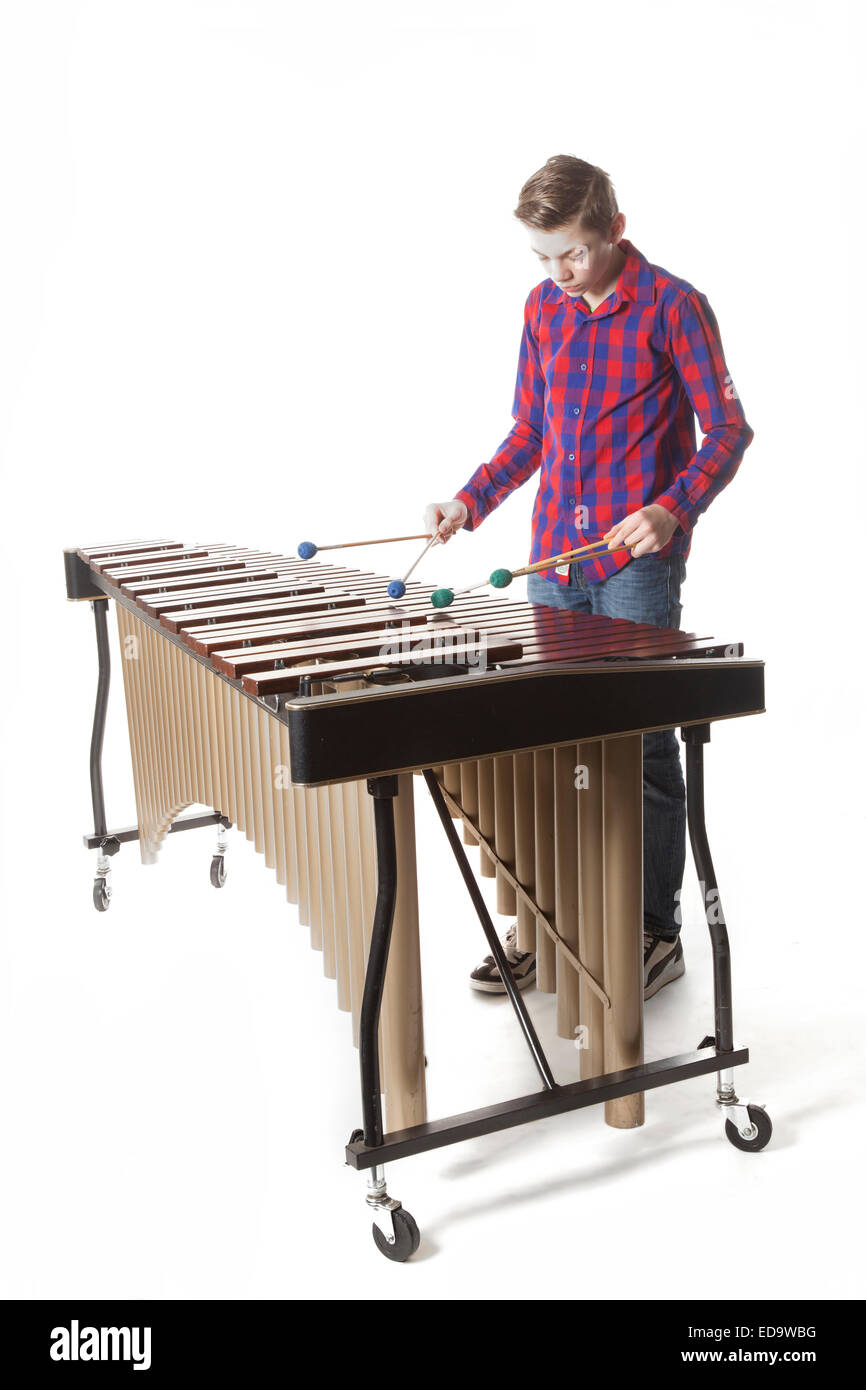 teenage boy playing the marimba in studio against white background ...