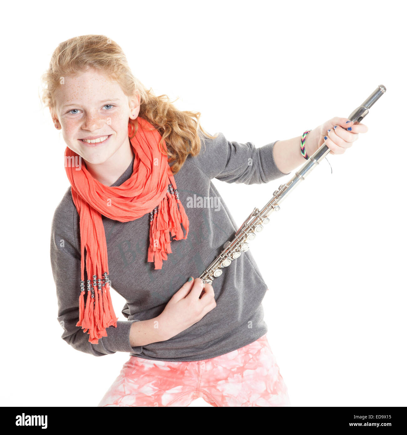 young girl with red hair and freckles holding flute in studio against ...