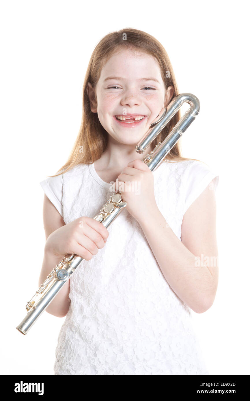 young girl with red hair and missing teeth holding flute in studio ...