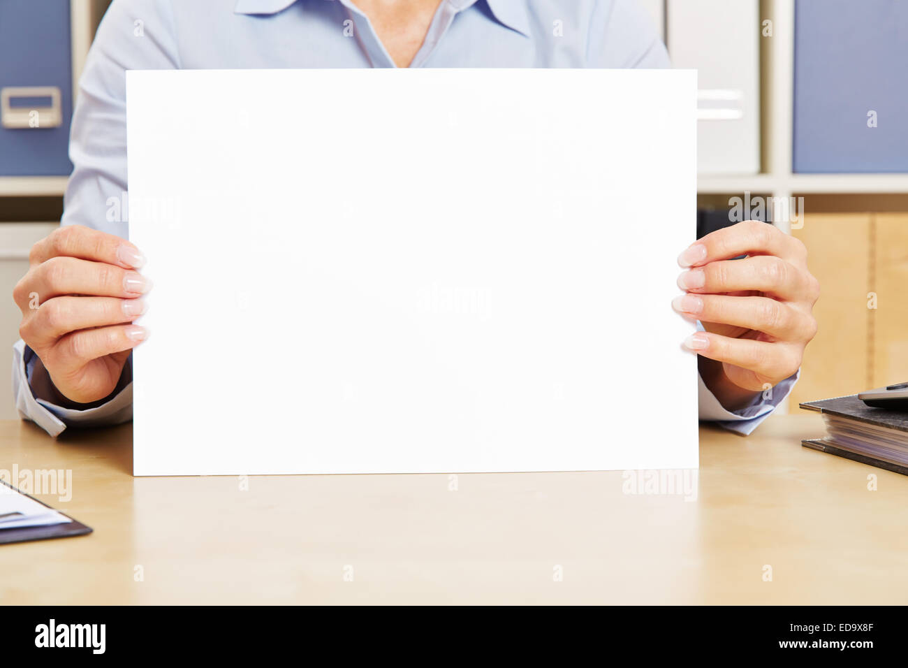 Two female hands holding empty white sheet of paper in an office Stock ...