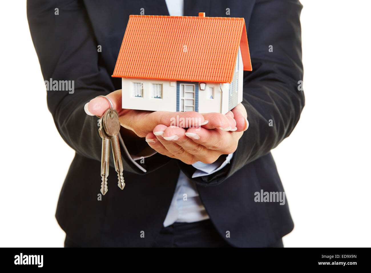 Hands of a female real estate broker holding a small house and keys ...