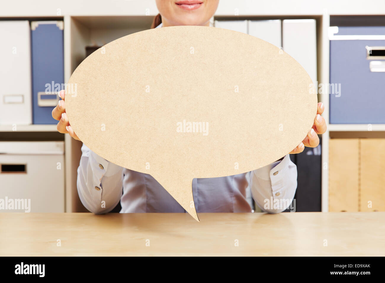 Woman holding big empty speech bubble on desk in her office Stock Photo ...