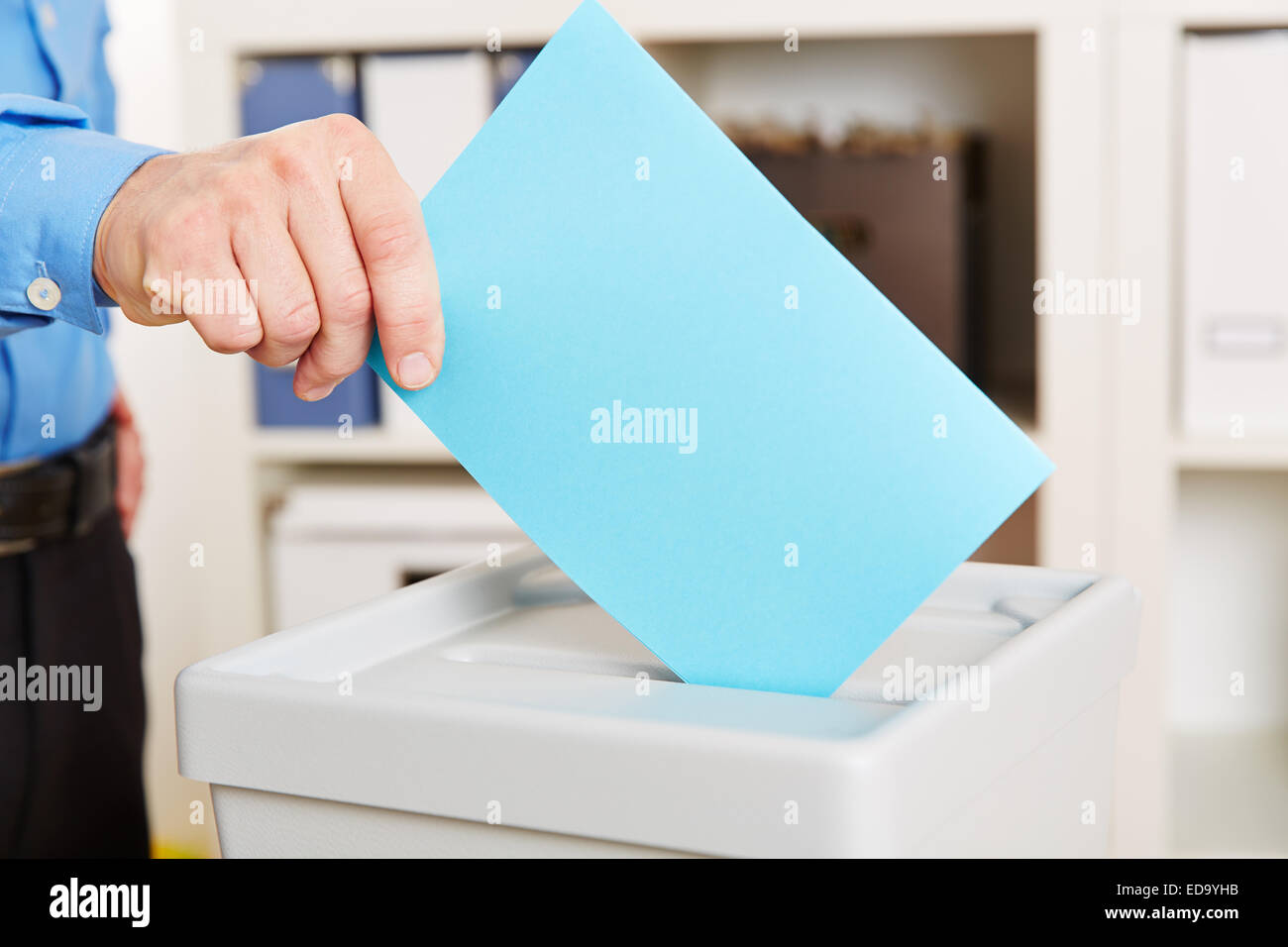 Hand with ballot paper an voting booth during election Stock Photo - Alamy