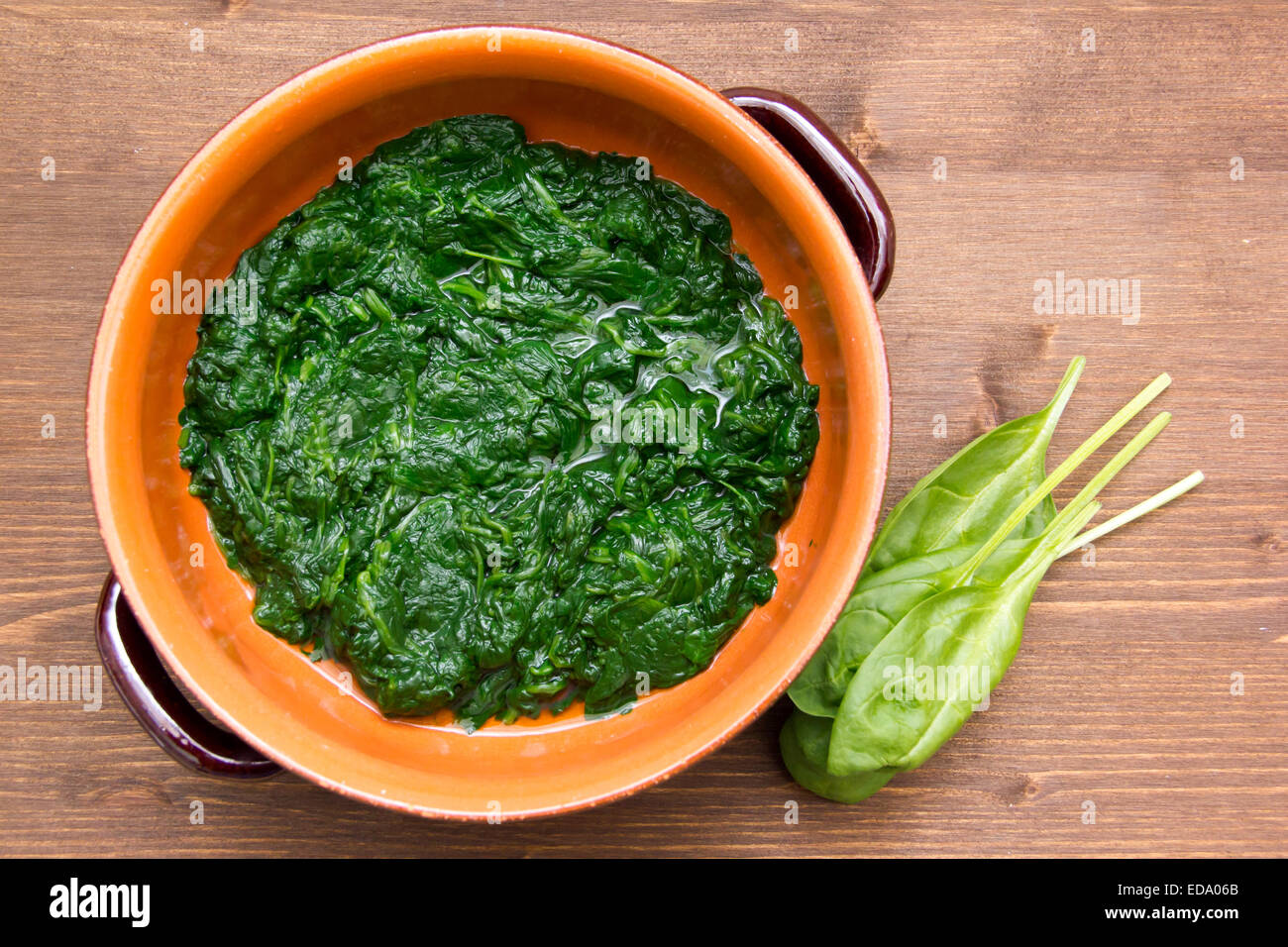 Spinach cooked in a pan on wooden table seen from above Stock Photo - Alamy