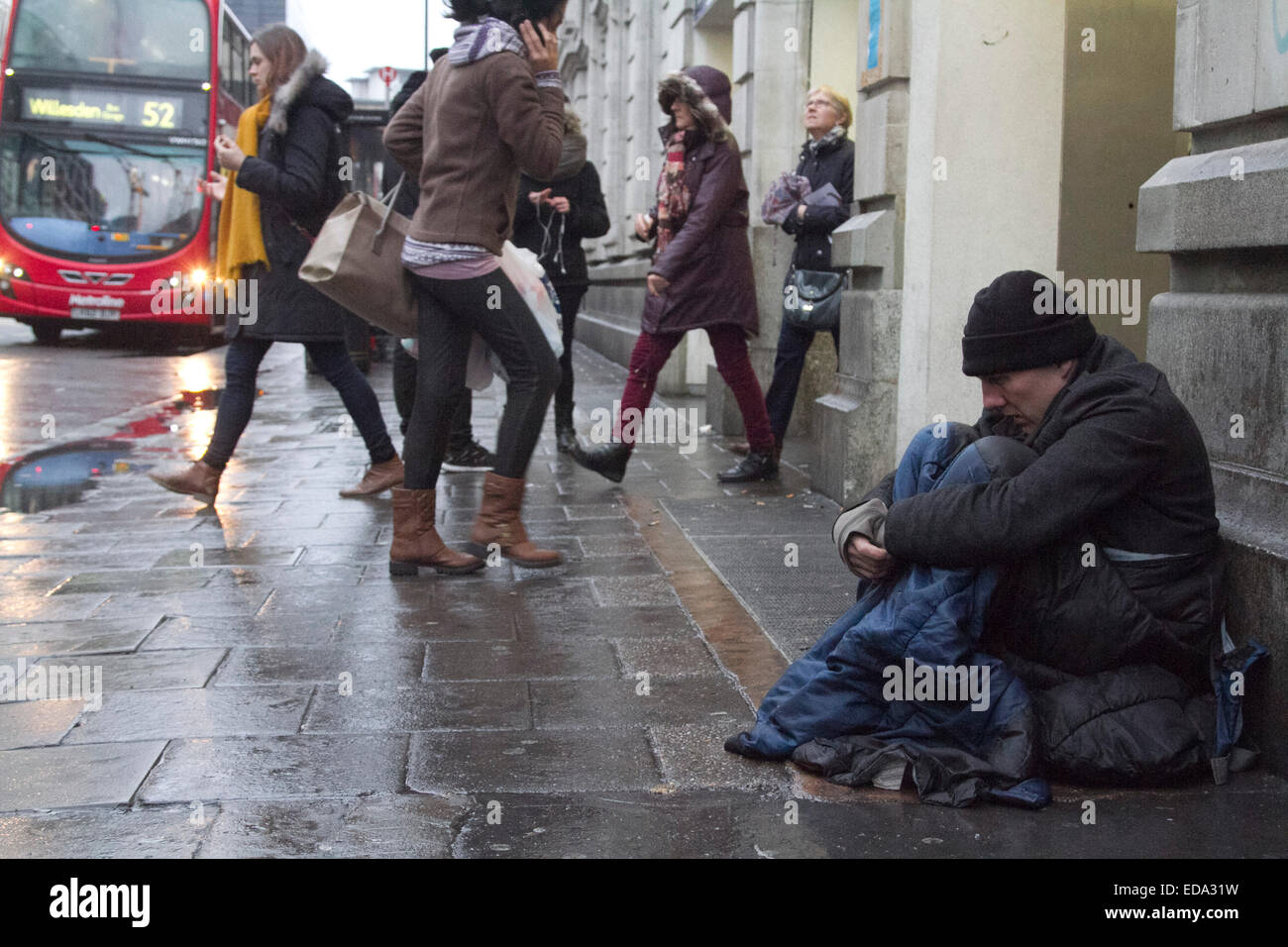 London, UK. 3rd January 2015. A homeless man sits at the entrance of ...
