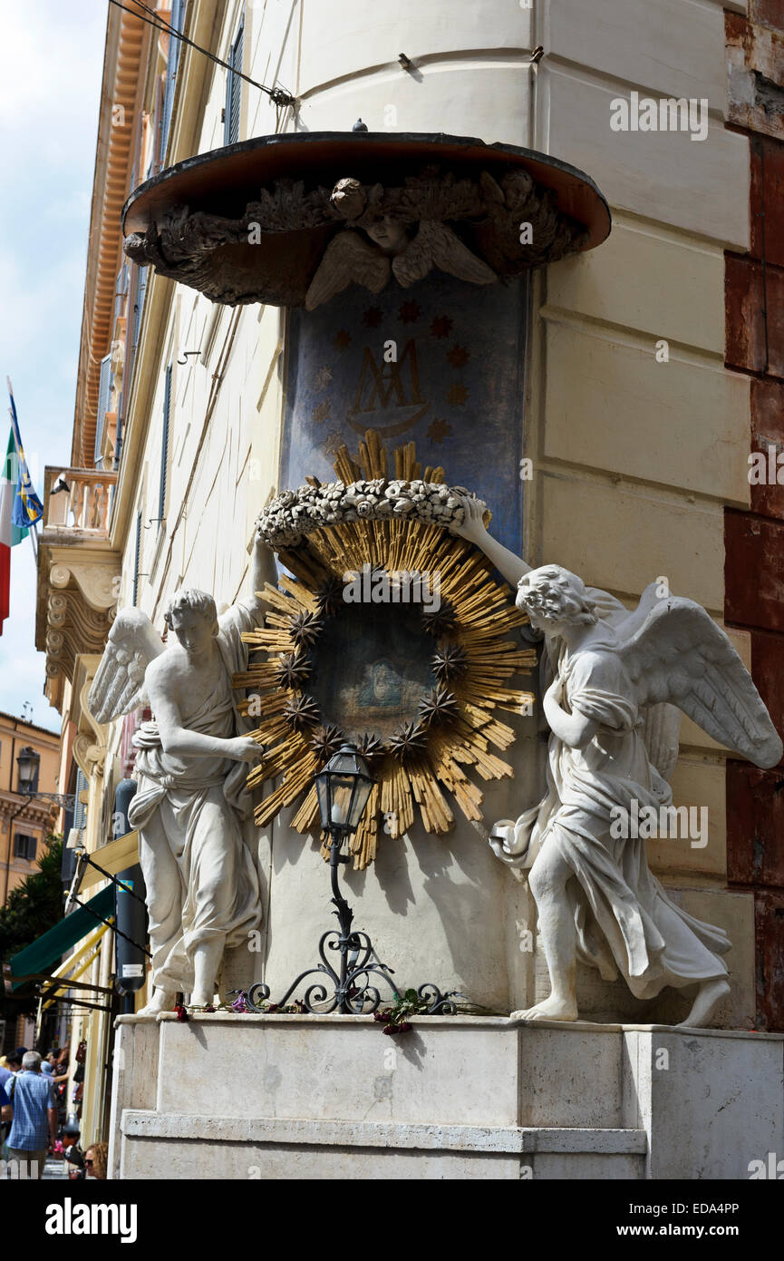 Two male angels standing by circular decoration on the wall of a ...