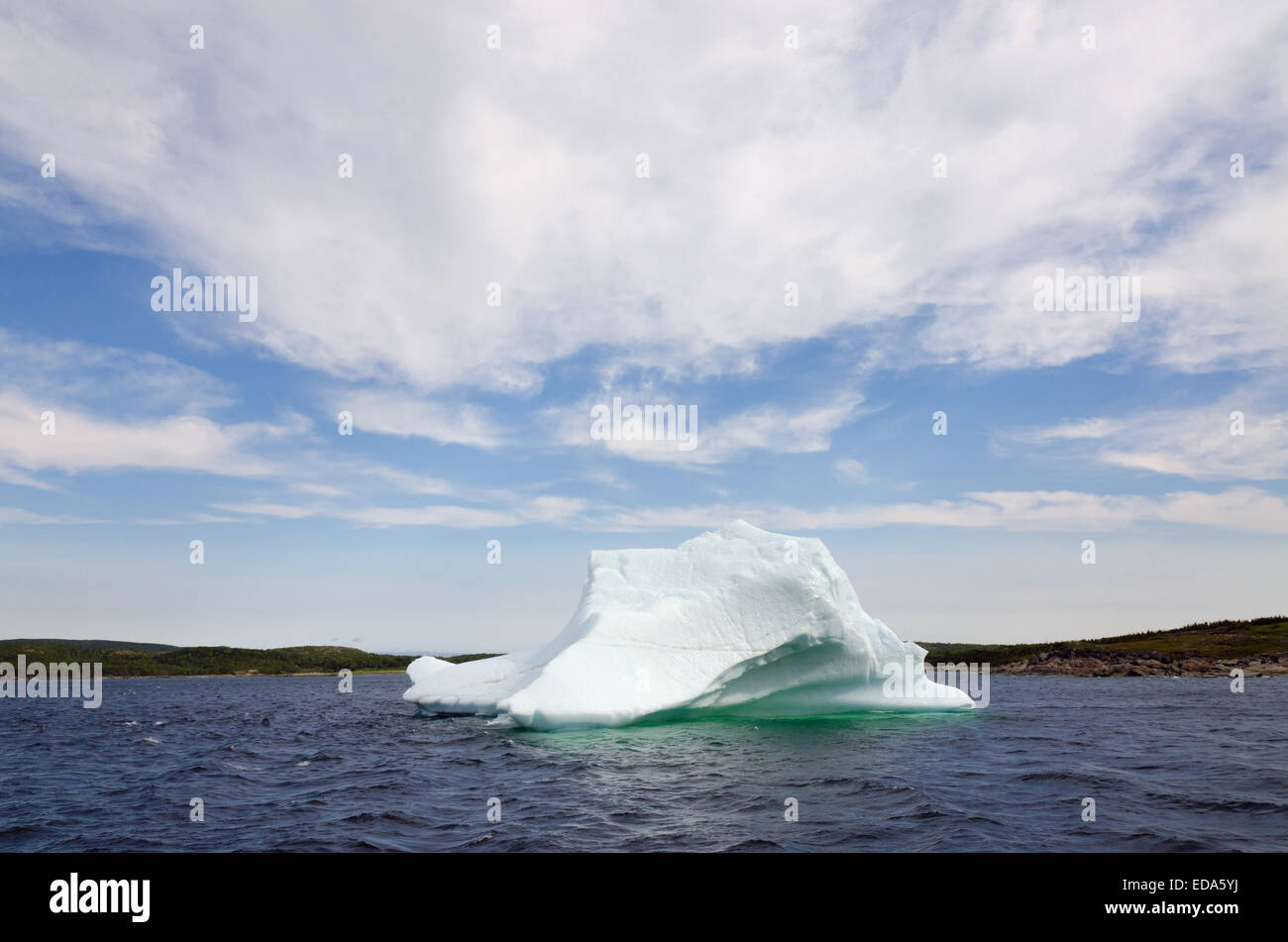 Bright white iceberg on dark water and rock background Stock Photo - Alamy
