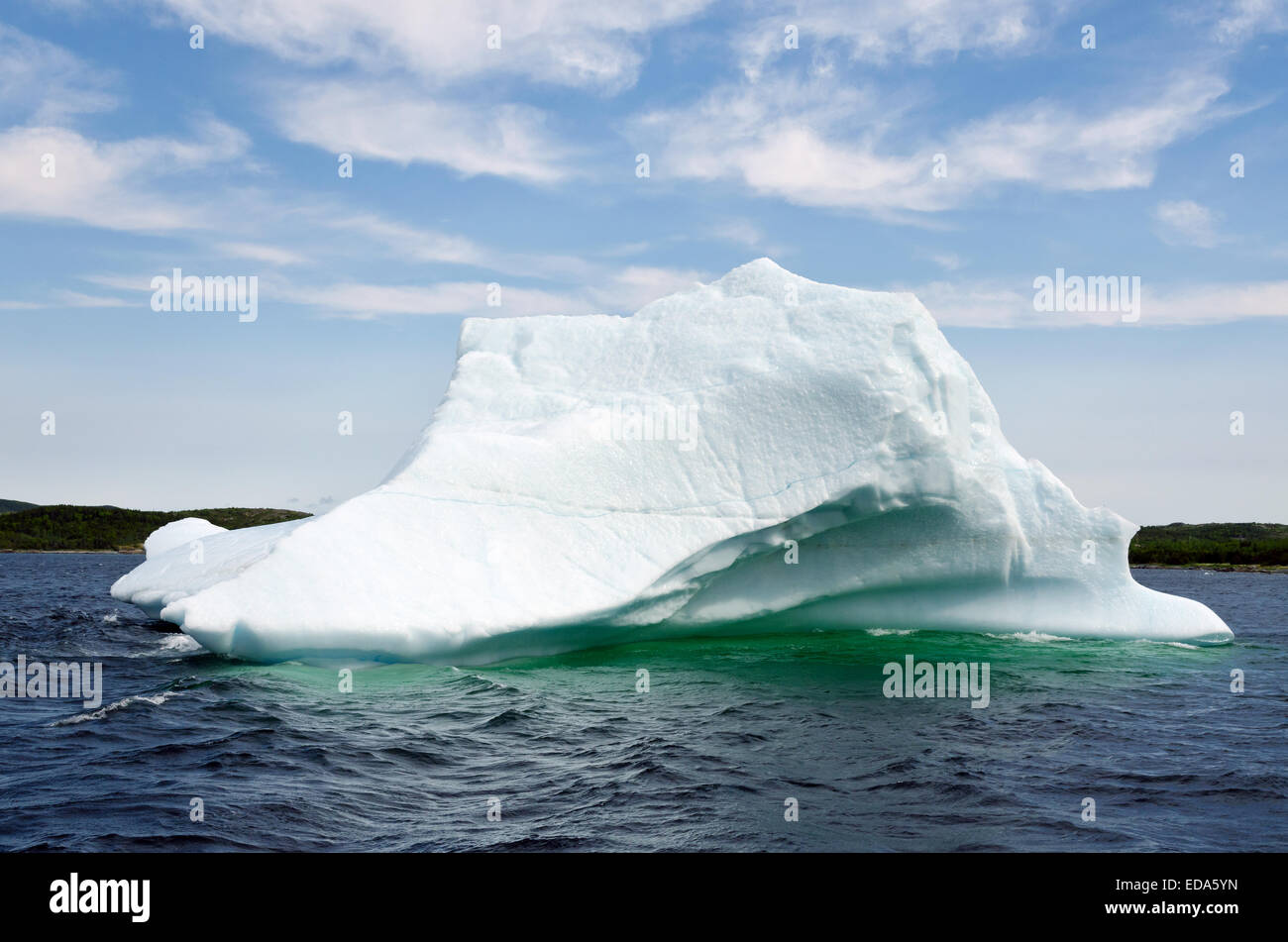 Bright white iceberg on dark water and rock background Stock Photo - Alamy