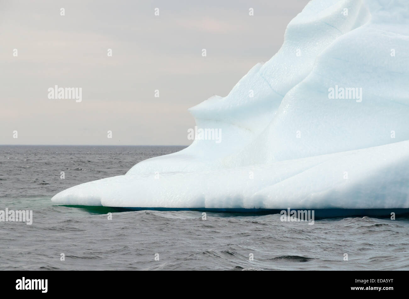 Bright white iceberg on dark water and rock background Stock Photo - Alamy