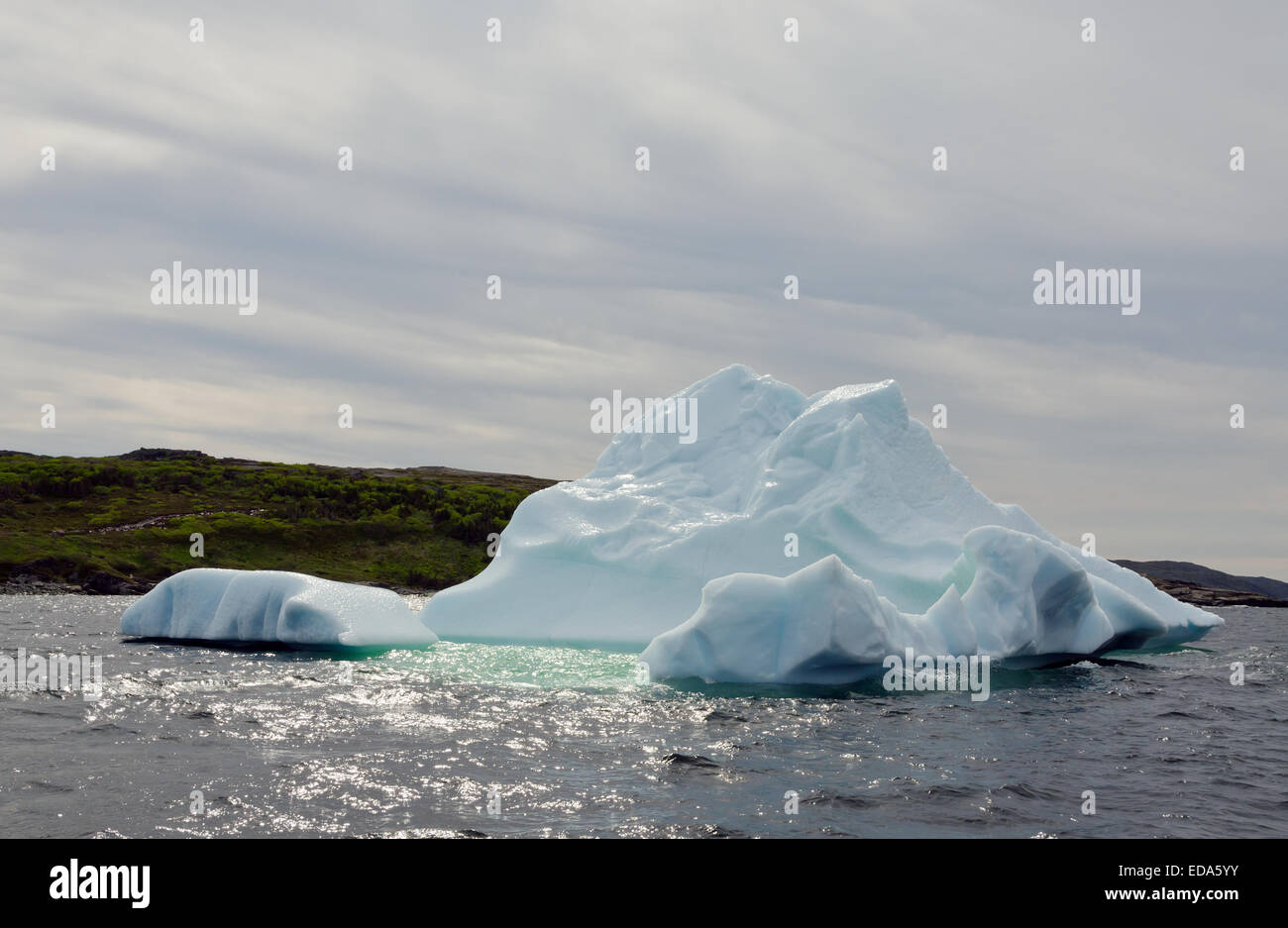 Bright white iceberg on dark water and rock background Stock Photo - Alamy