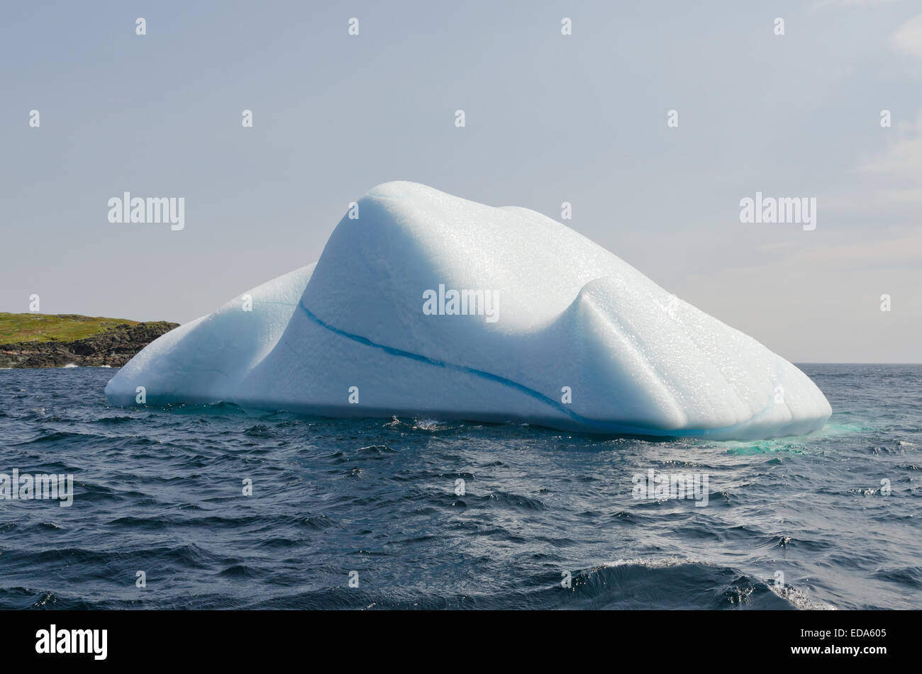 Bright white iceberg on dark water and rock background Stock Photo - Alamy