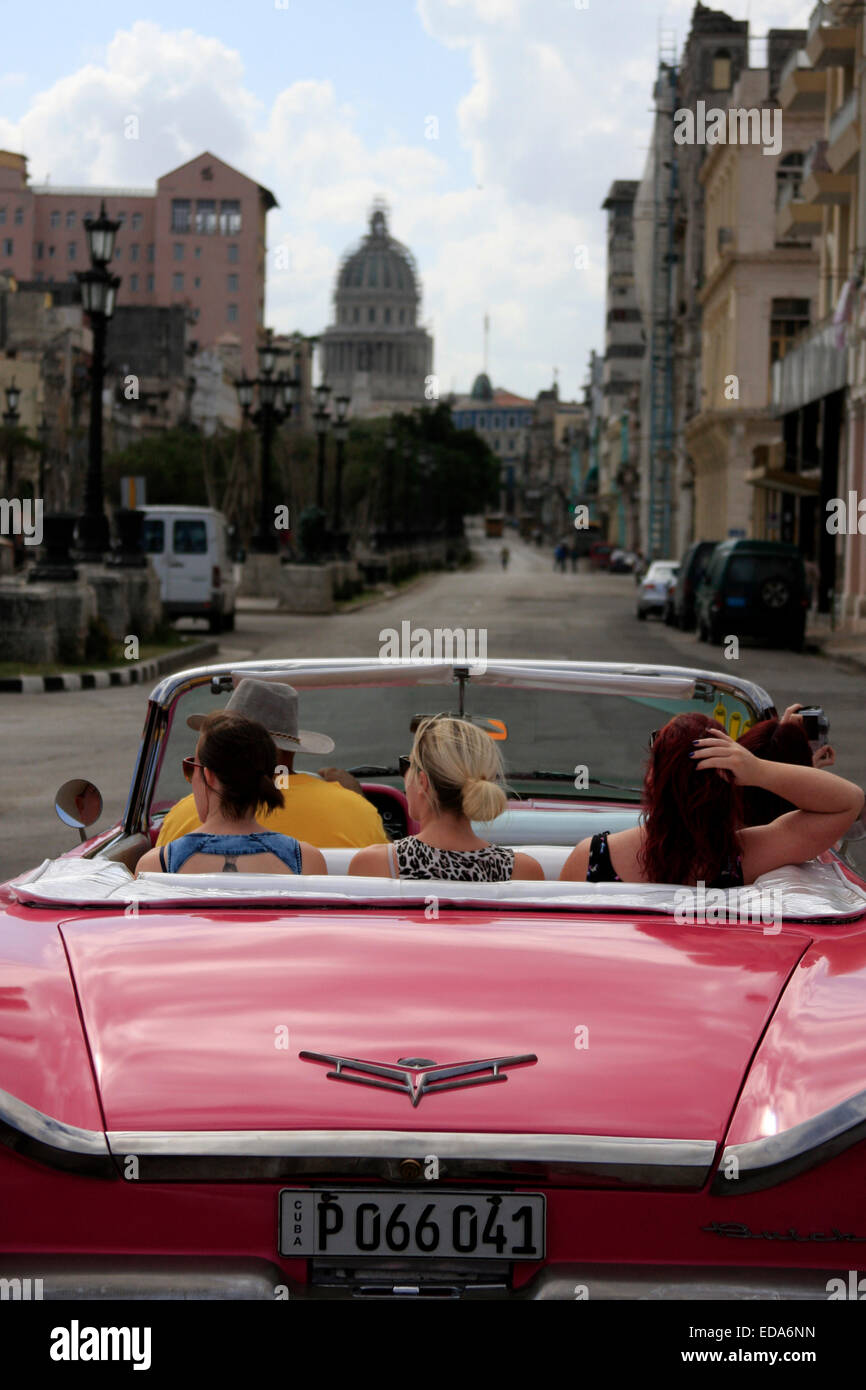 Tourists traveling in a classic vintage convertible car in Havana, Cuba ...