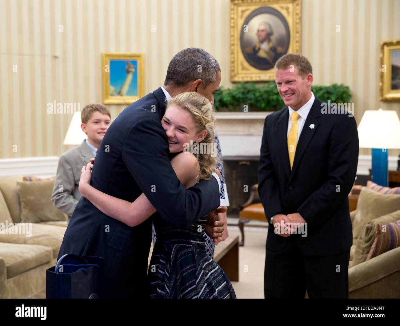 US President Barack Obama hugs Parker McAllen, 13 in the Oval Office of ...