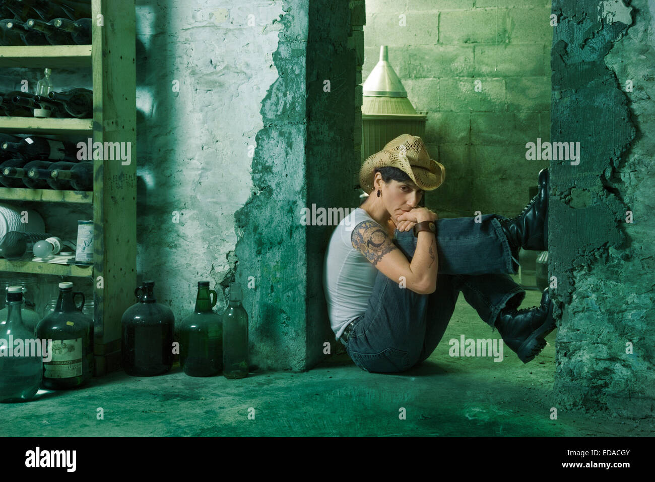 Woman leaning up against wall in basement Stock Photo - Alamy
