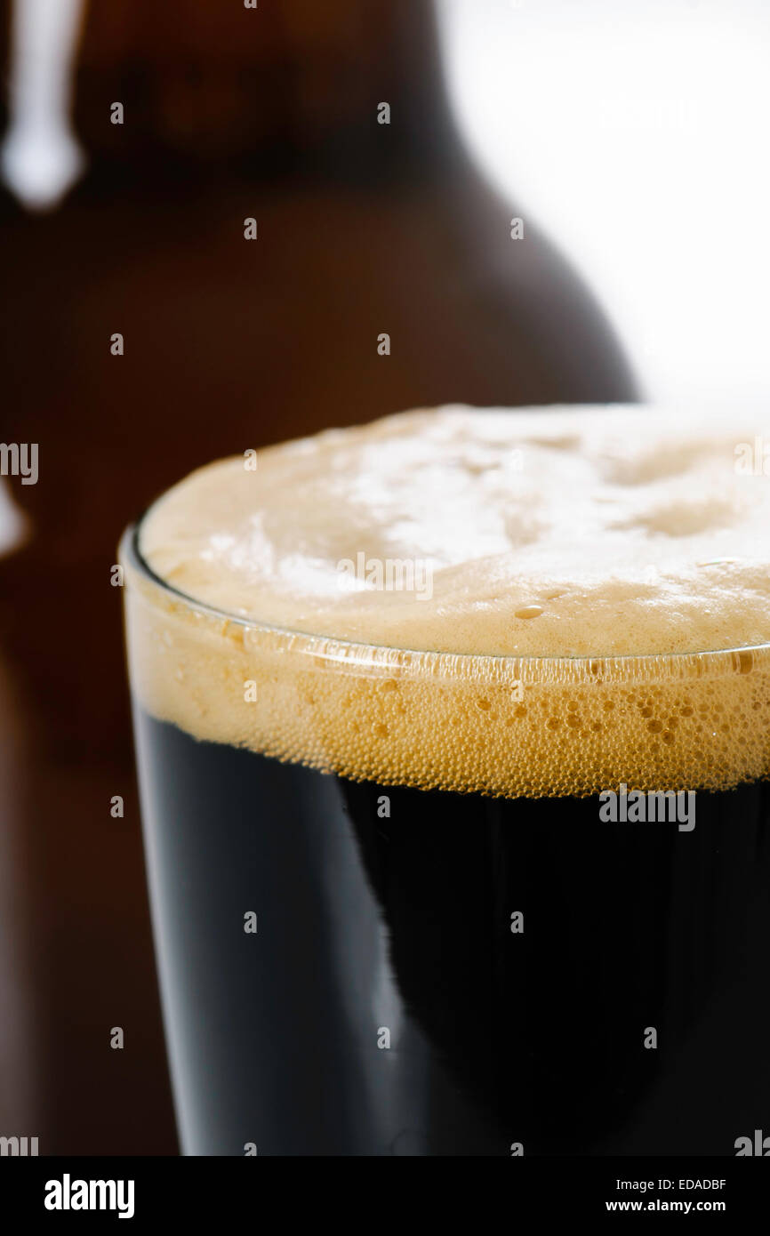 Dark Stout beer with bottle on white Stock Photo - Alamy
