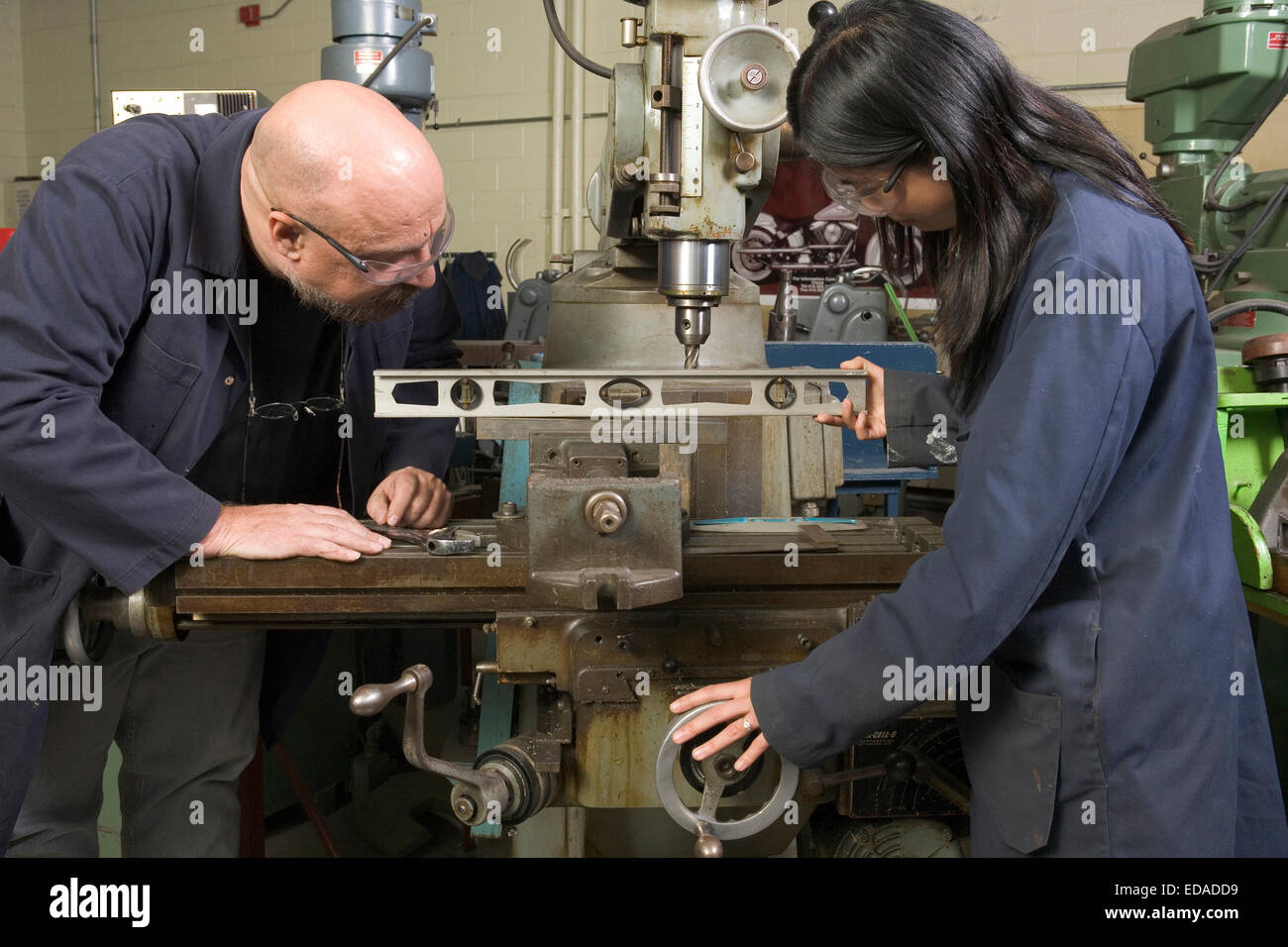 Teacher showing student in metal shop Stock Photo - Alamy