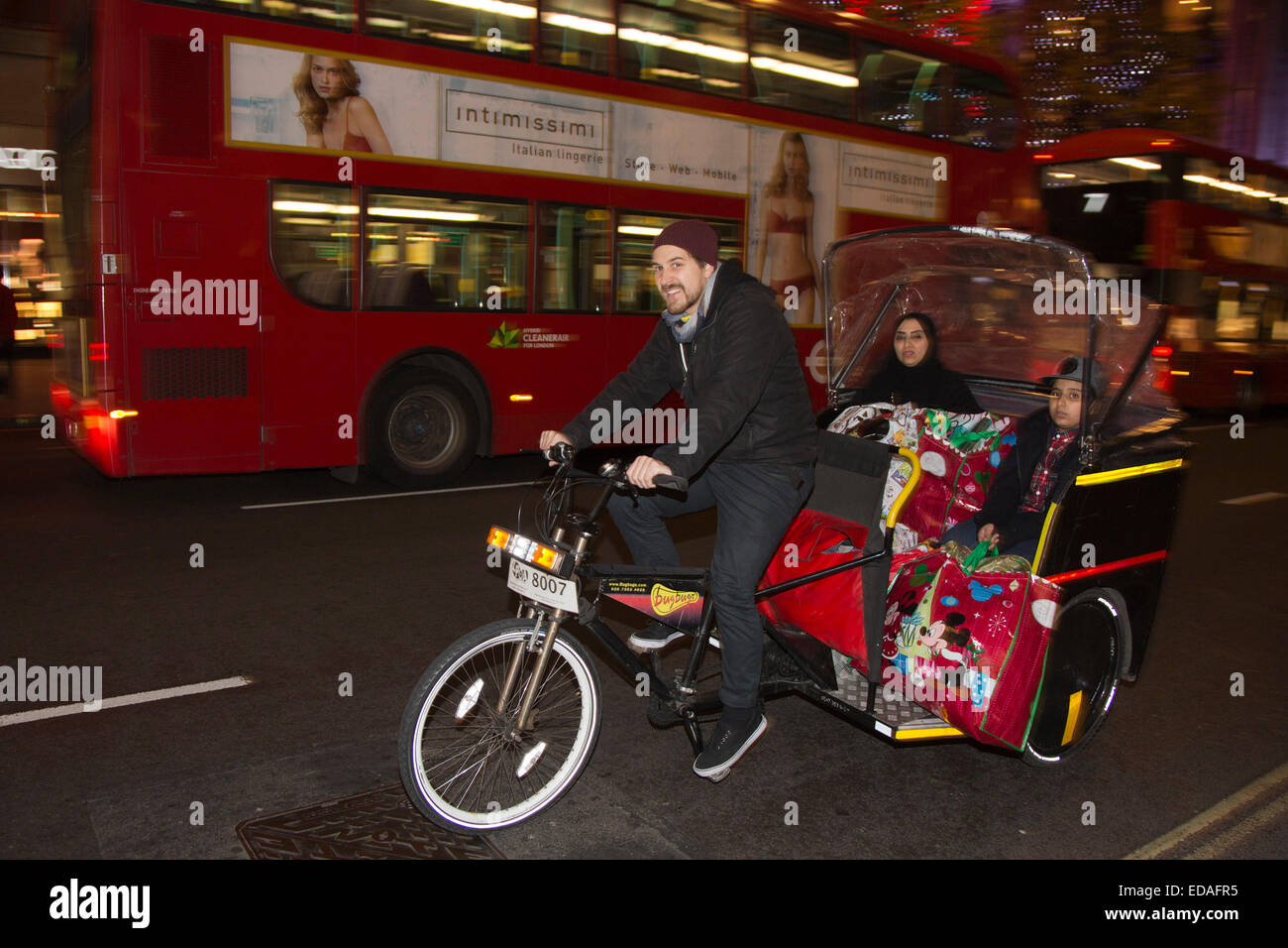 A rickshaw with customers in Oxford Street at night, London, England ...