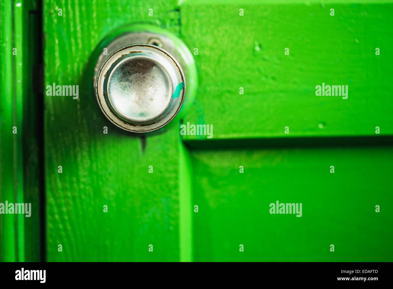 Part of green wooden door. Metallic doorhandle Stock Photo - Alamy