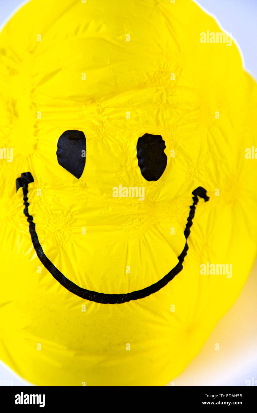 old Balloon, yellow, shriveled with friendly smiley face, sunken ...