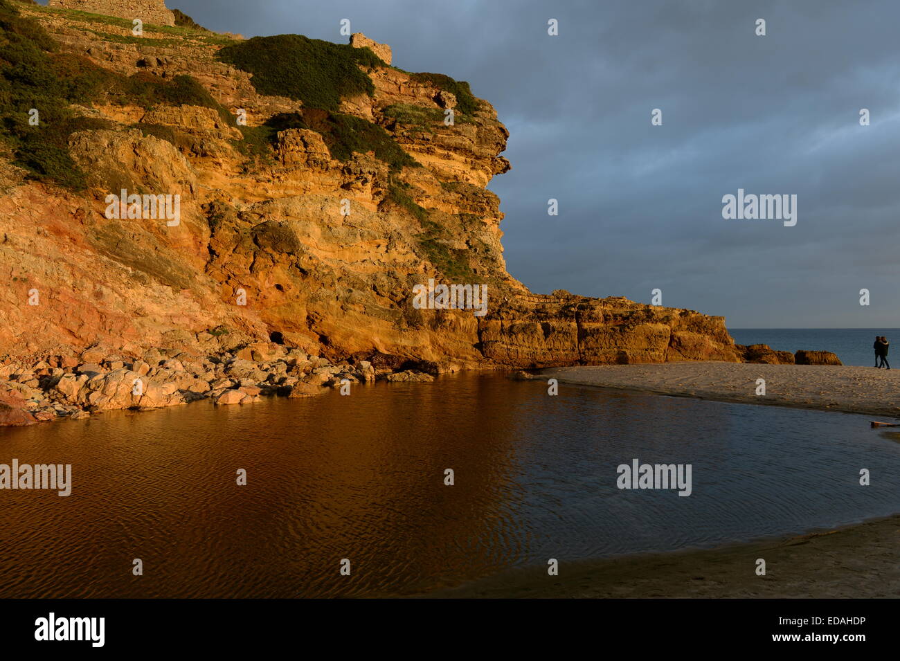 yellow colored cliffs at Figuiera beach glow in the setting sun Stock ...