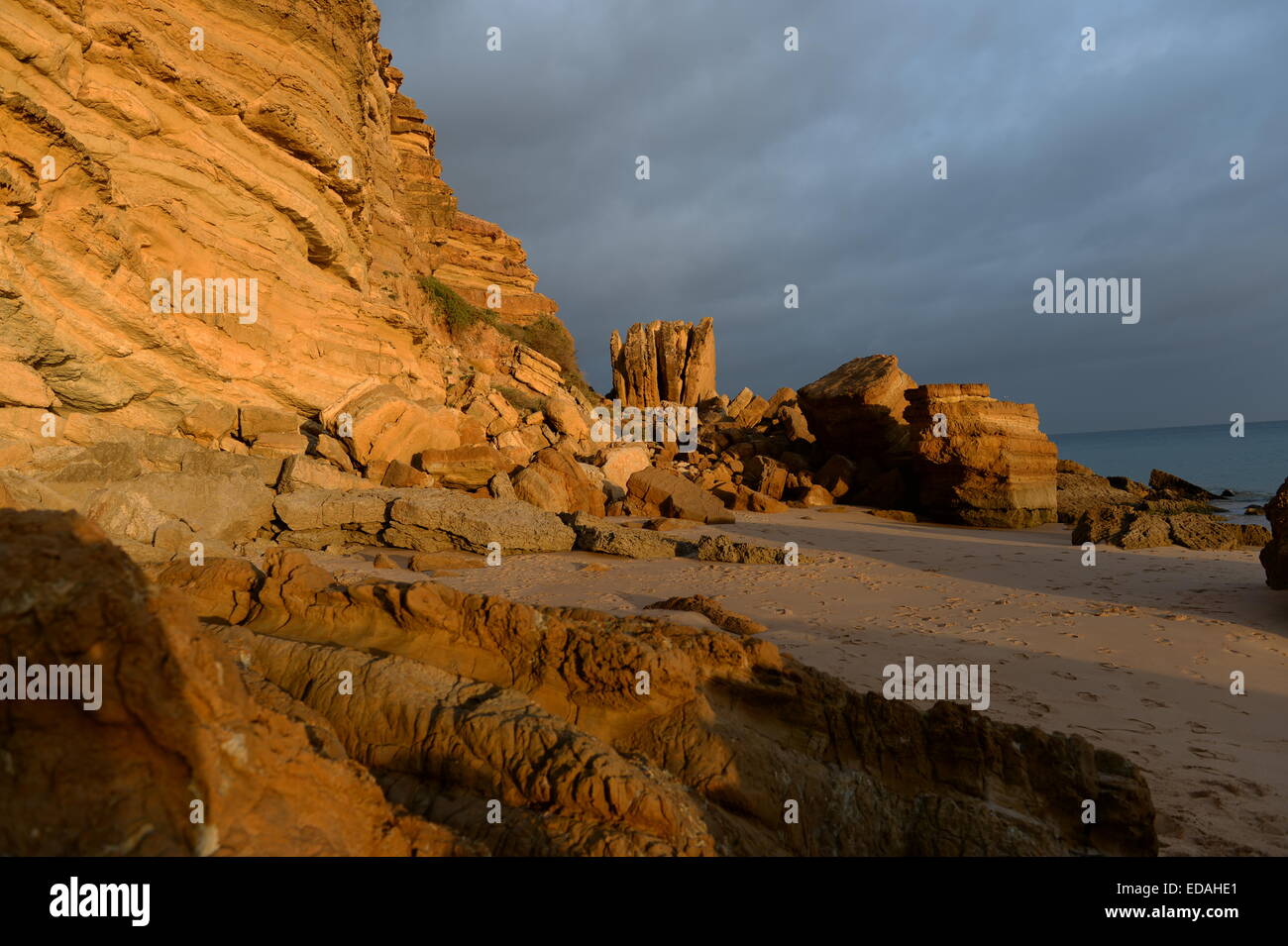 yellow colored cliffs at Figuiera beach glow in the setting sun Stock ...
