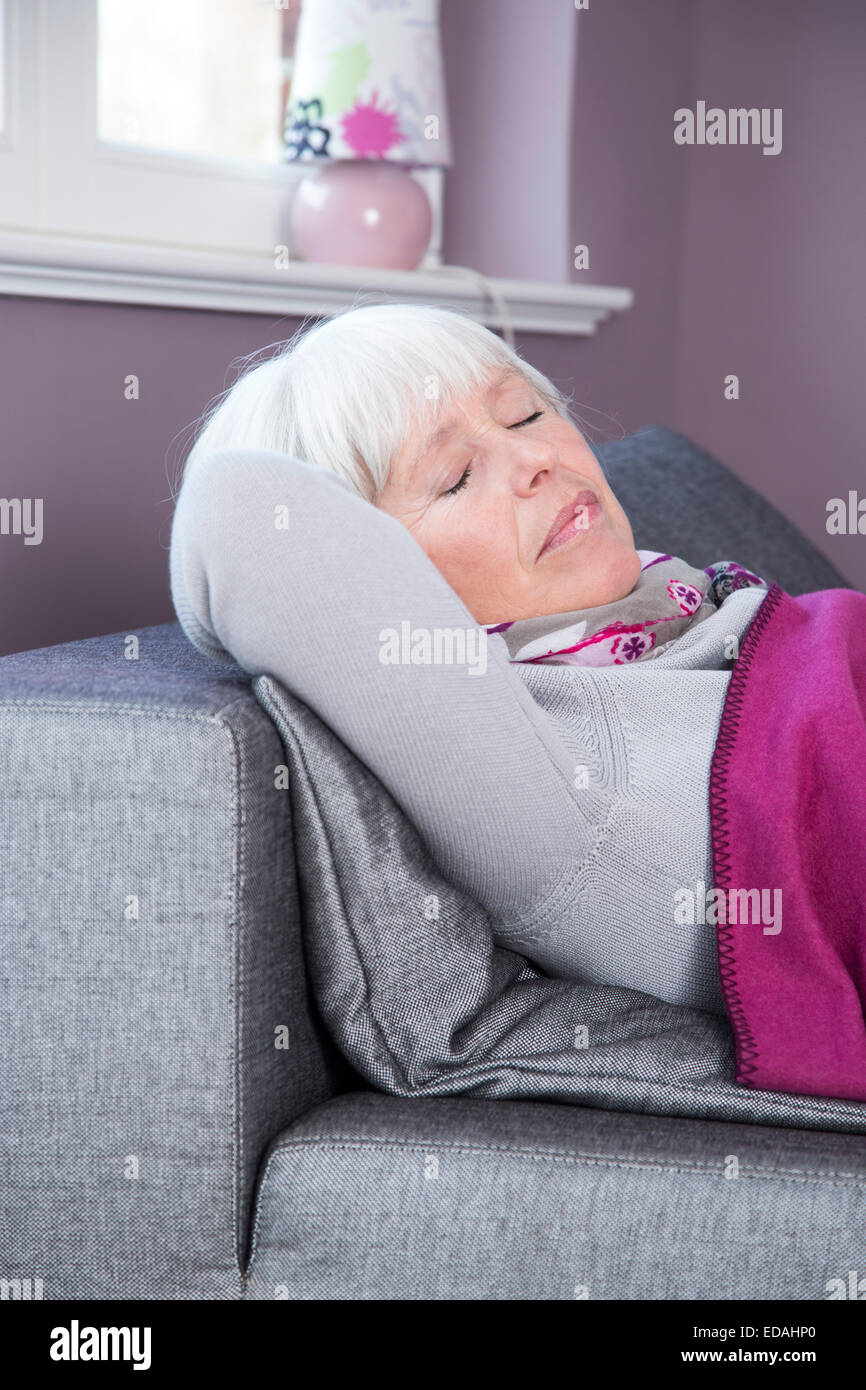 Senior woman napping on sofa hi-res stock photography and images - Alamy