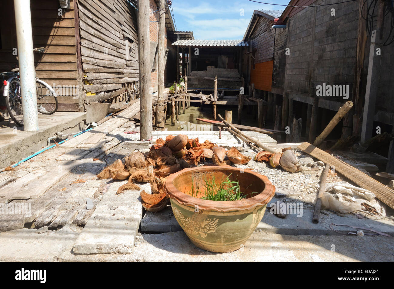 Pile of peeled coconut husk shells with chinese bowl, stilt houses ...