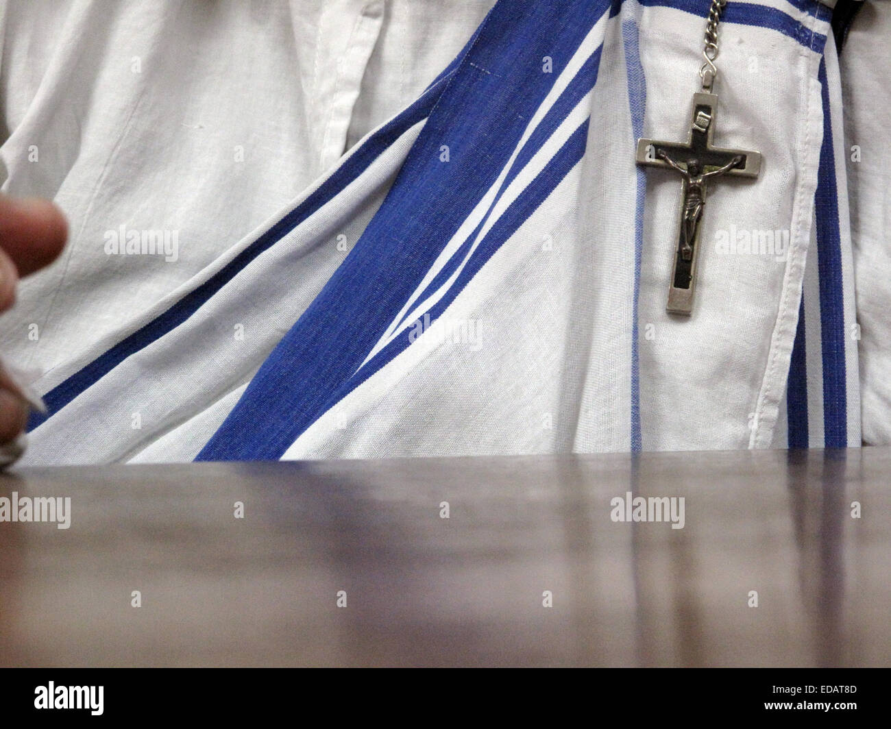 White sari with blue stripes and a crucifix are recognizable sign of ...