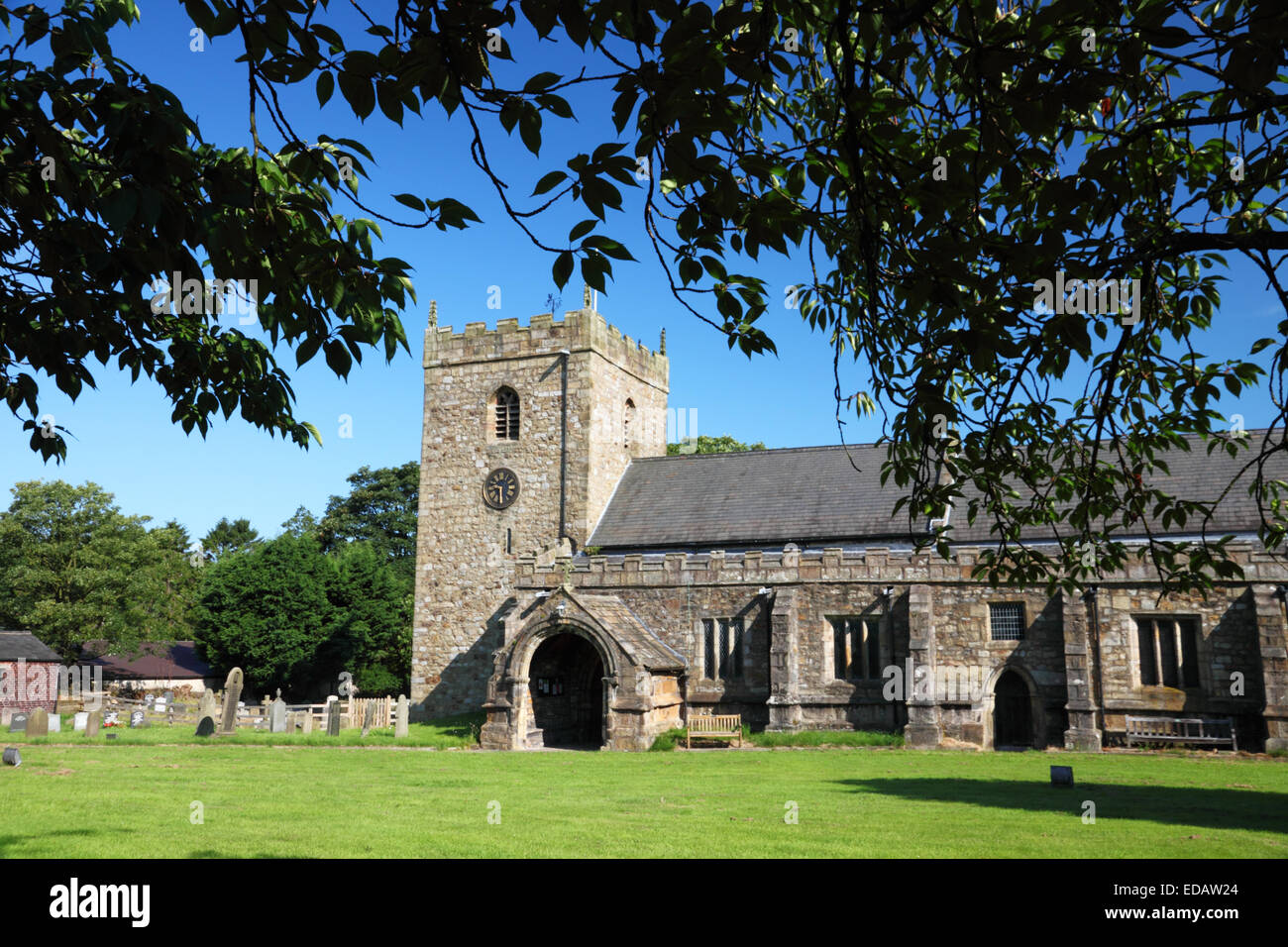 A church with a squat tower under foliage Stock Photo - Alamy