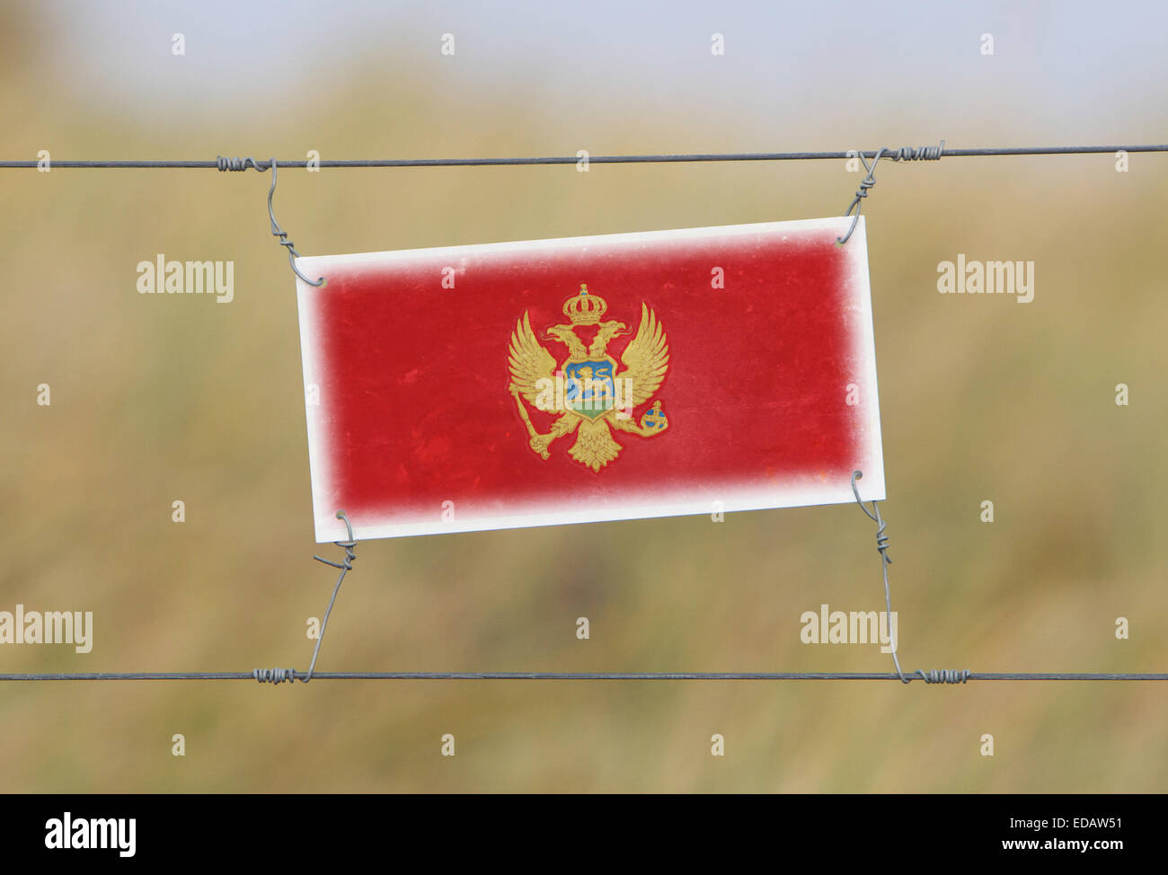 Border fence - Old plastic sign with a flag - Montenegro Stock Photo ...