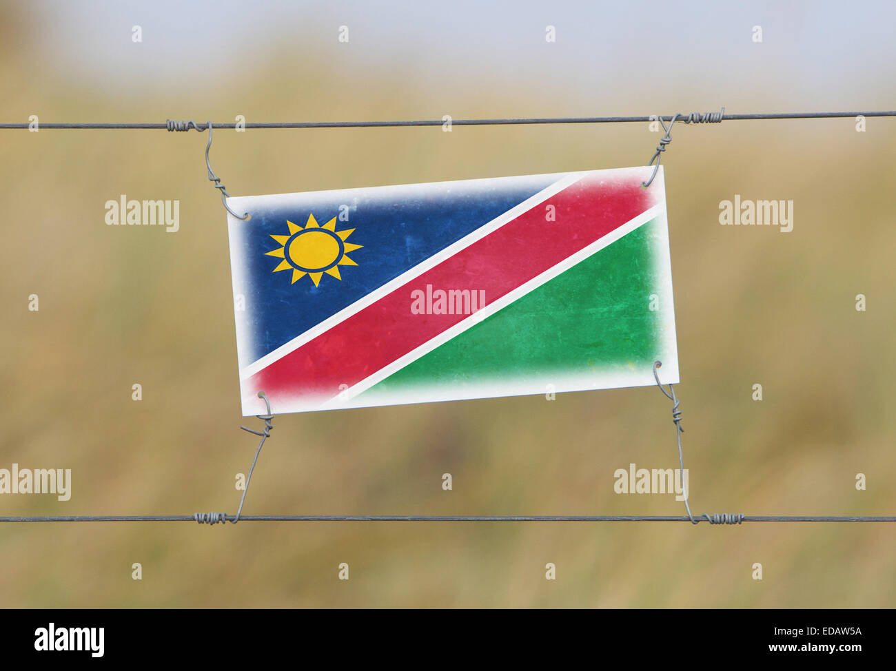 Border fence - Old plastic sign with a flag - Namibia Stock Photo - Alamy