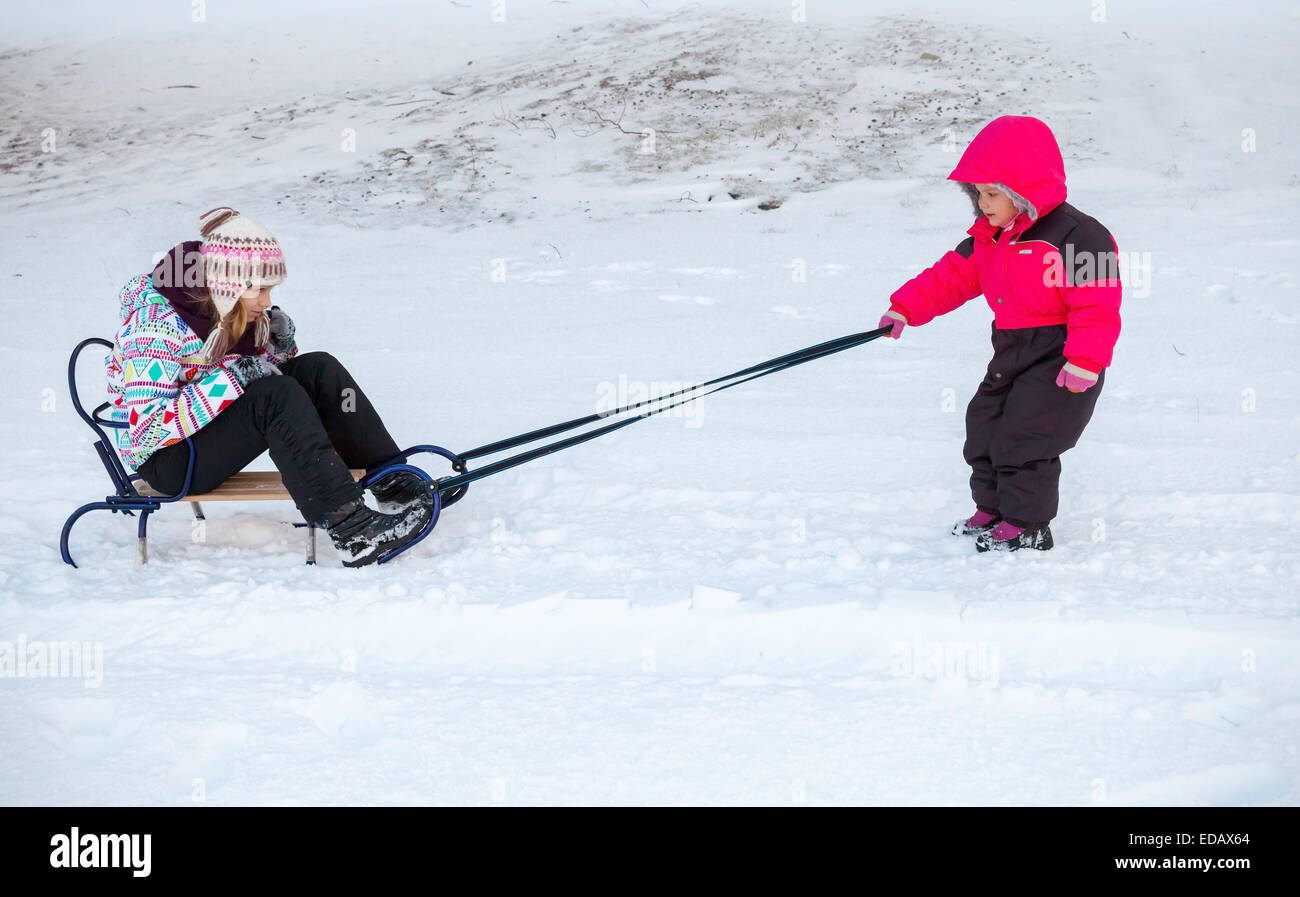 Little baby girl in pink pulling a sled on snowy winter road Stock ...