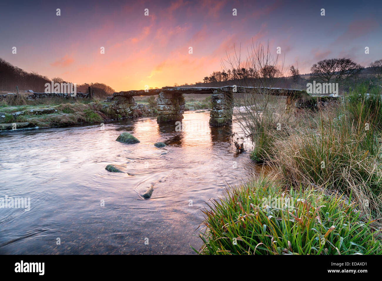 Dramatic vibrant sunrise over an ancient granite clapper bridge at ...