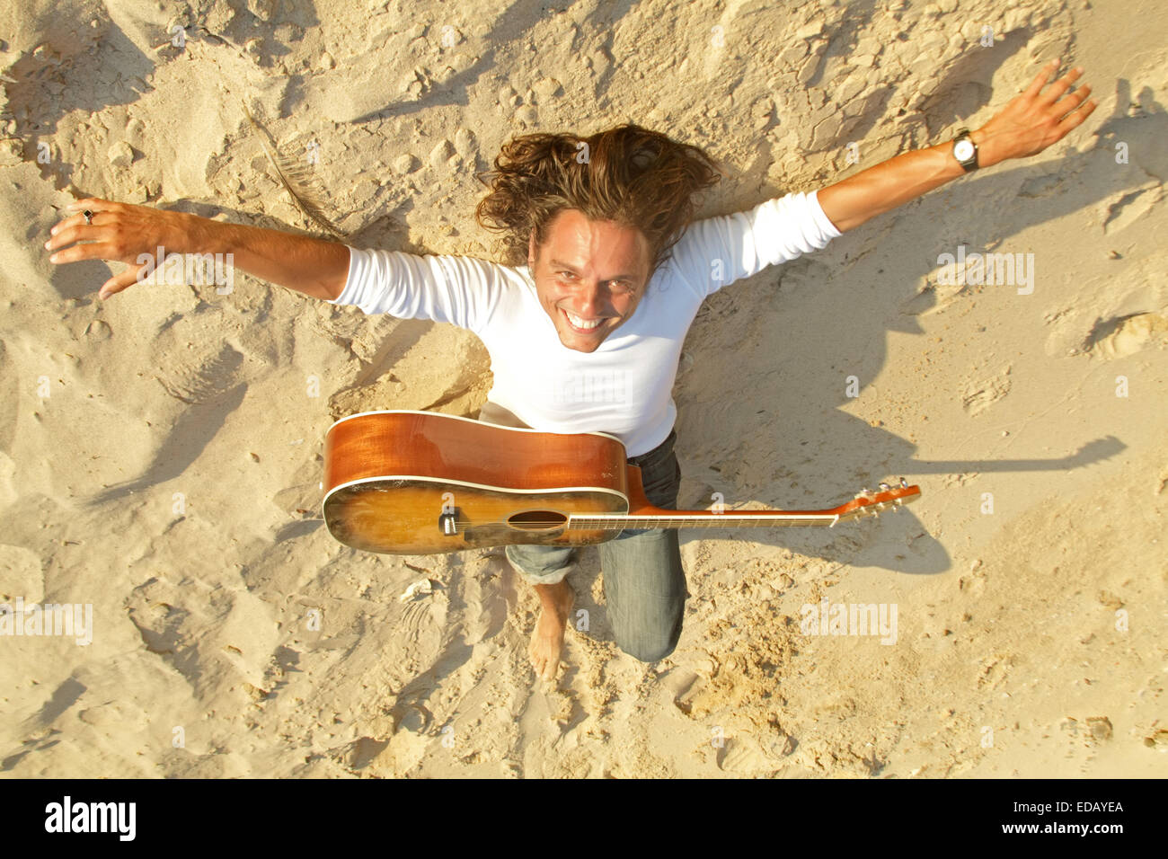 Guitar player in the sand on the beach Stock Photo - Alamy