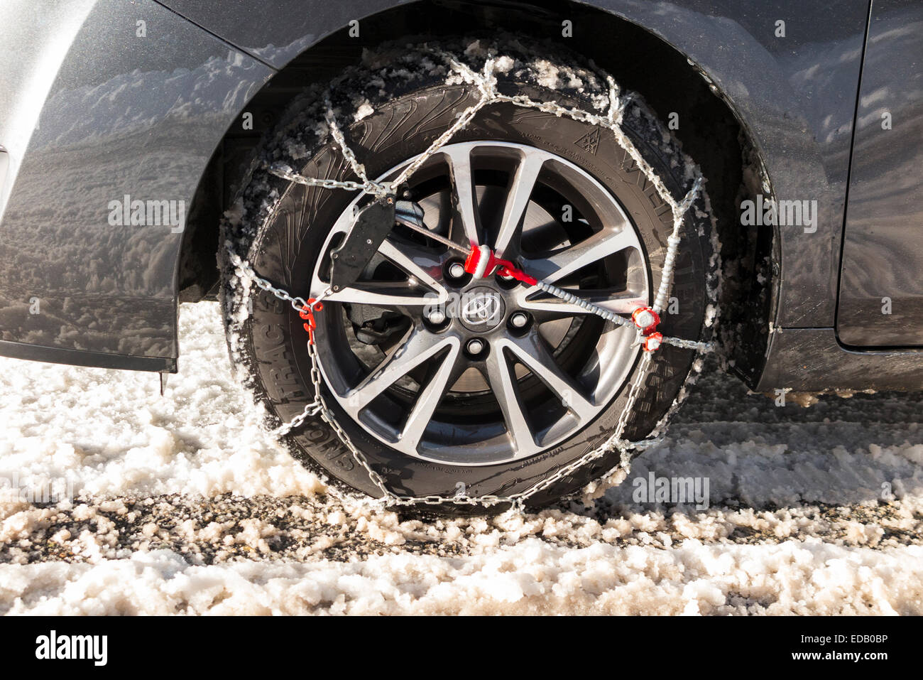 Snow chain / chains on front wheel / wheels of a car also fitted with ...
