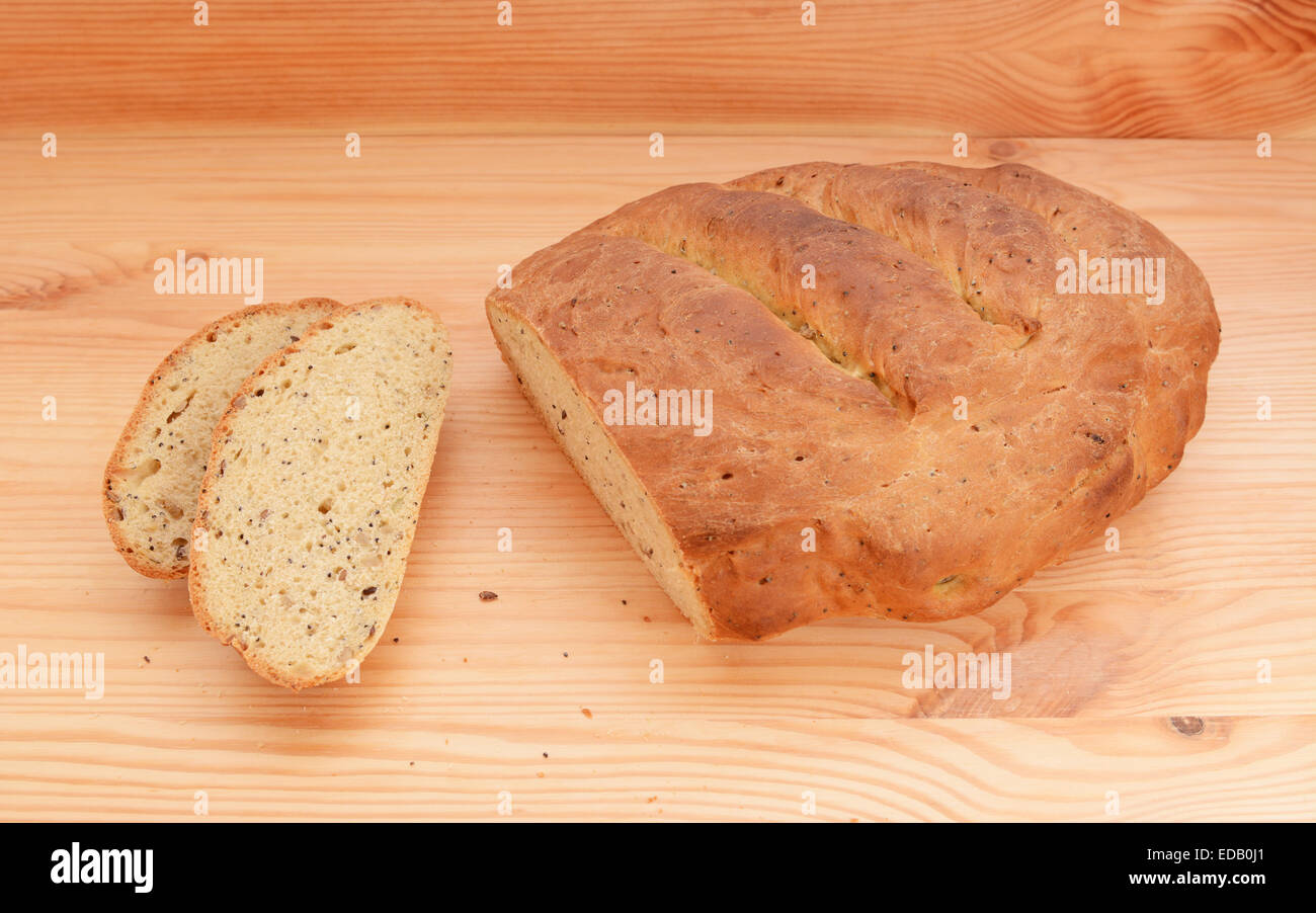 Two slices of bread cut from a fresh multi seed loaf on a wooden table ...