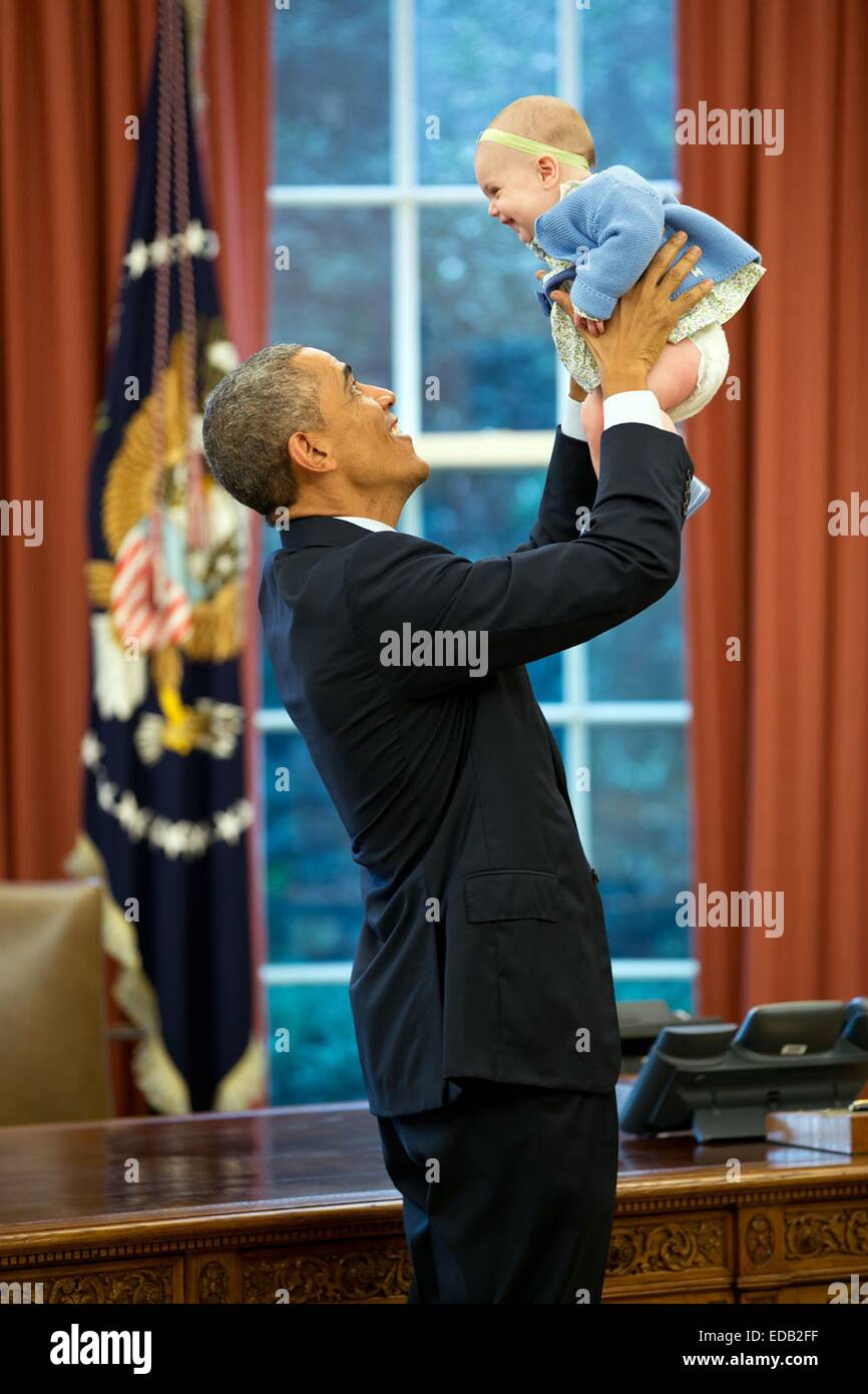 US President Barack Obama plays with a baby of a departing staff member ...