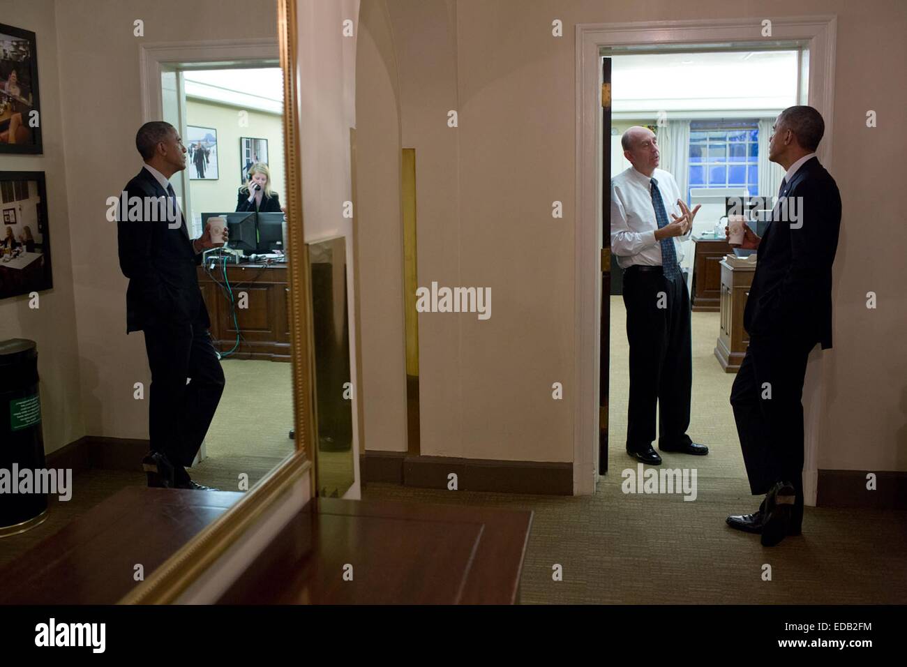 US President Barack Obama is reflected in the mirror as he speaks with ...