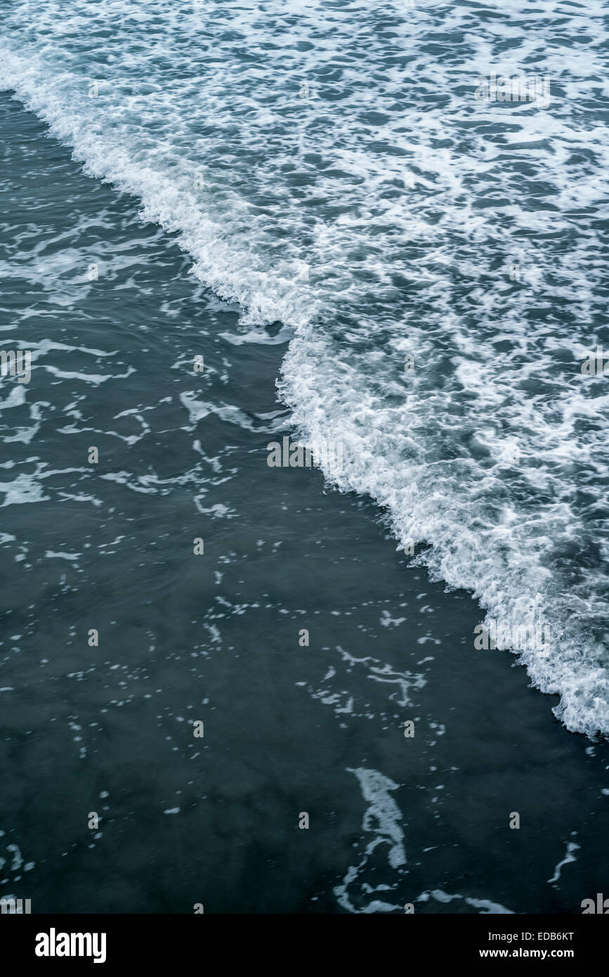 waves create abstract patterns as they break on the shore Stock Photo ...