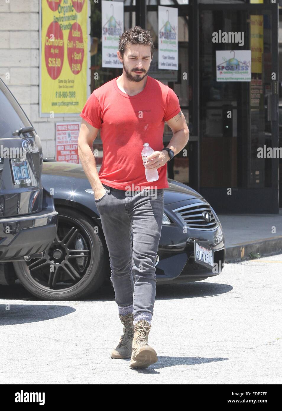 A bearded Shia LaBeouf wearing an old red 'Mighty Alpha Superstars 1981 ...