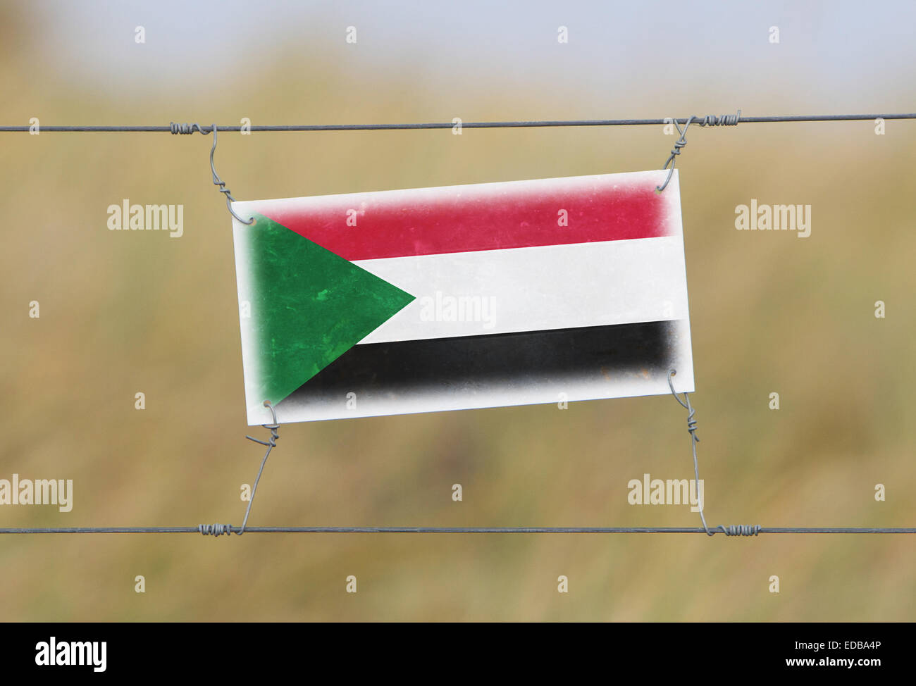 Border fence - Old plastic sign with a flag - Sudan Stock Photo - Alamy