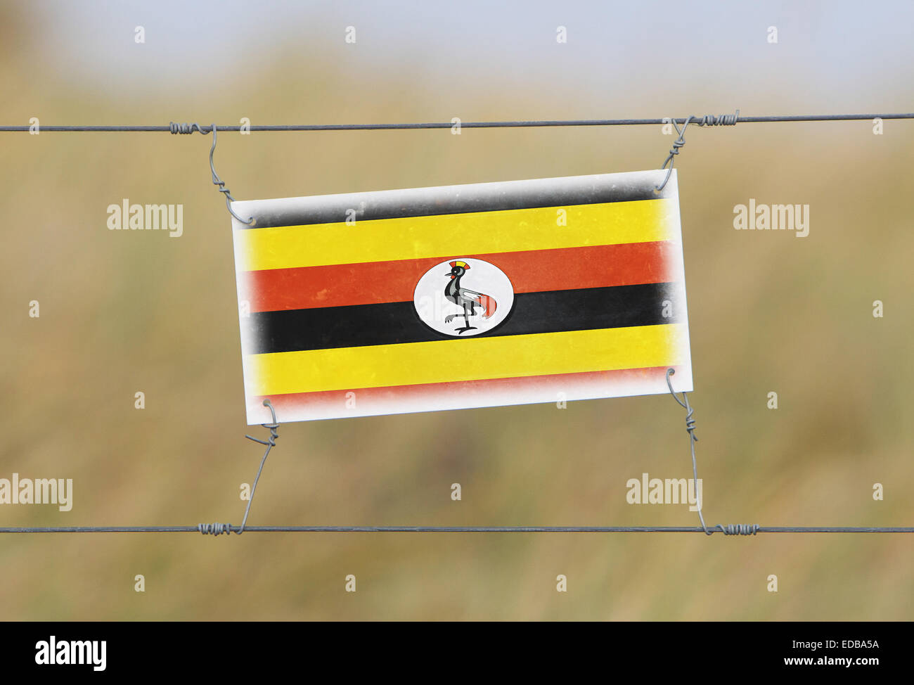 Border fence - Old plastic sign with a flag - Uganda Stock Photo - Alamy