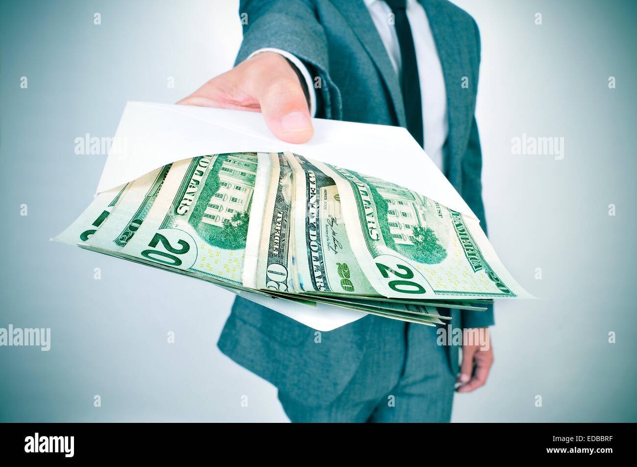 a man in suit giving an envelope full of american dollar bills Stock ...