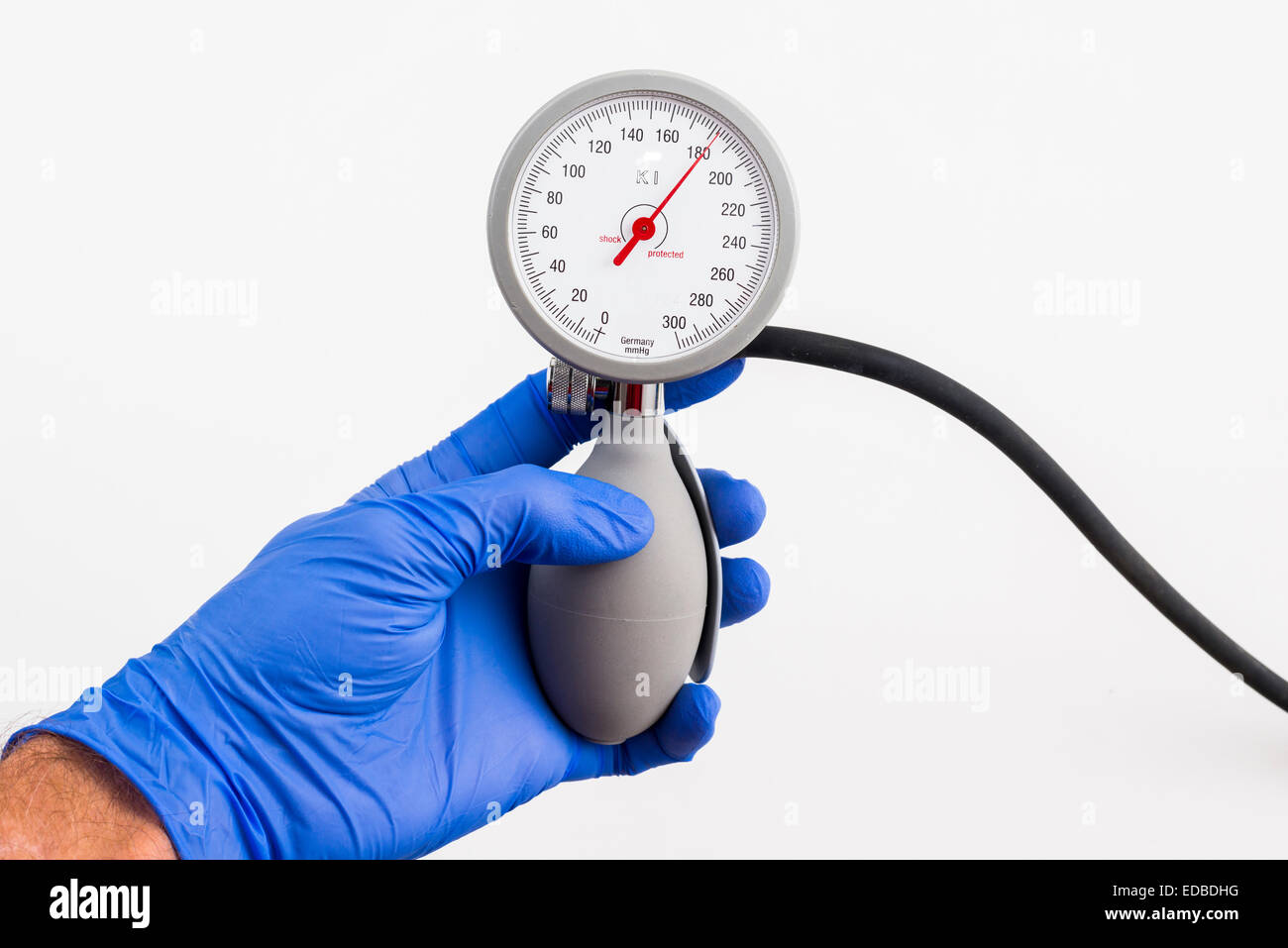 A hand with a blue medical glove is holding a sphygmomanometer, blood ...