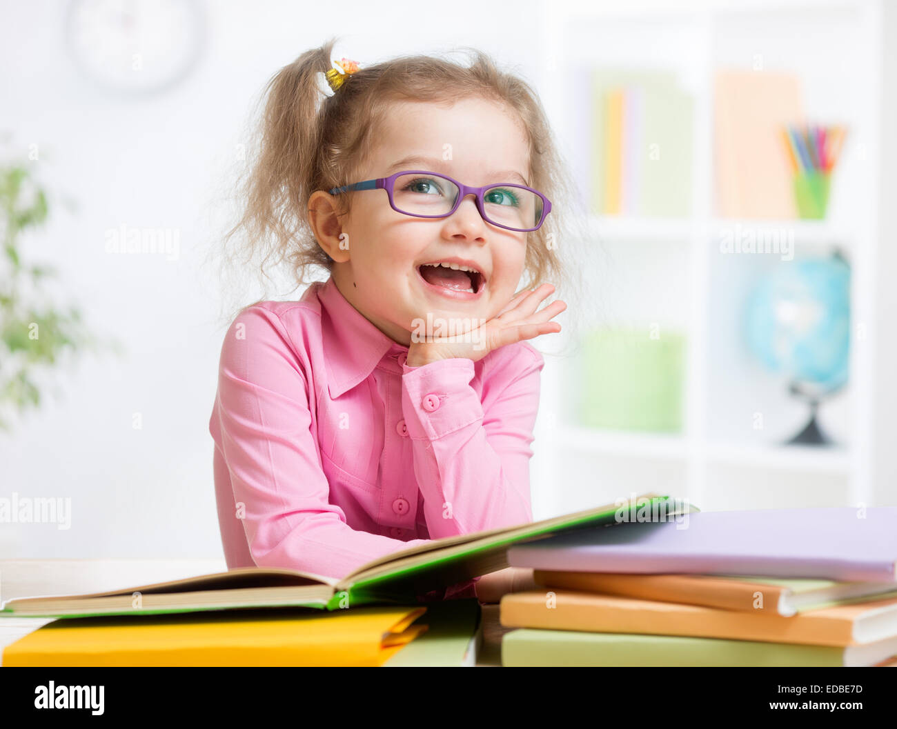 Happy kid reading books and dreaming Stock Photo - Alamy