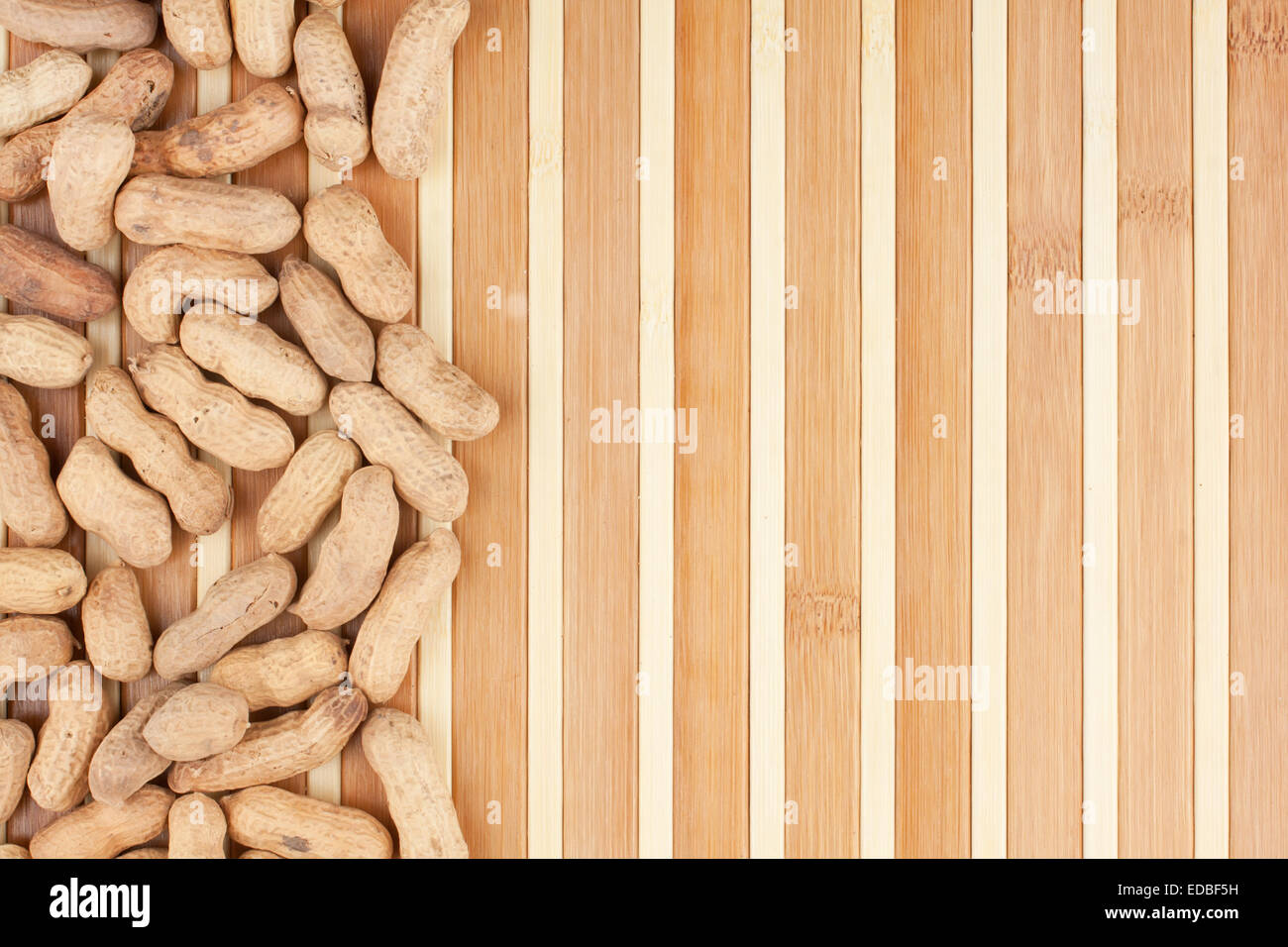 unpeeled peanuts lying on a bamboo mat can be used as background Stock ...