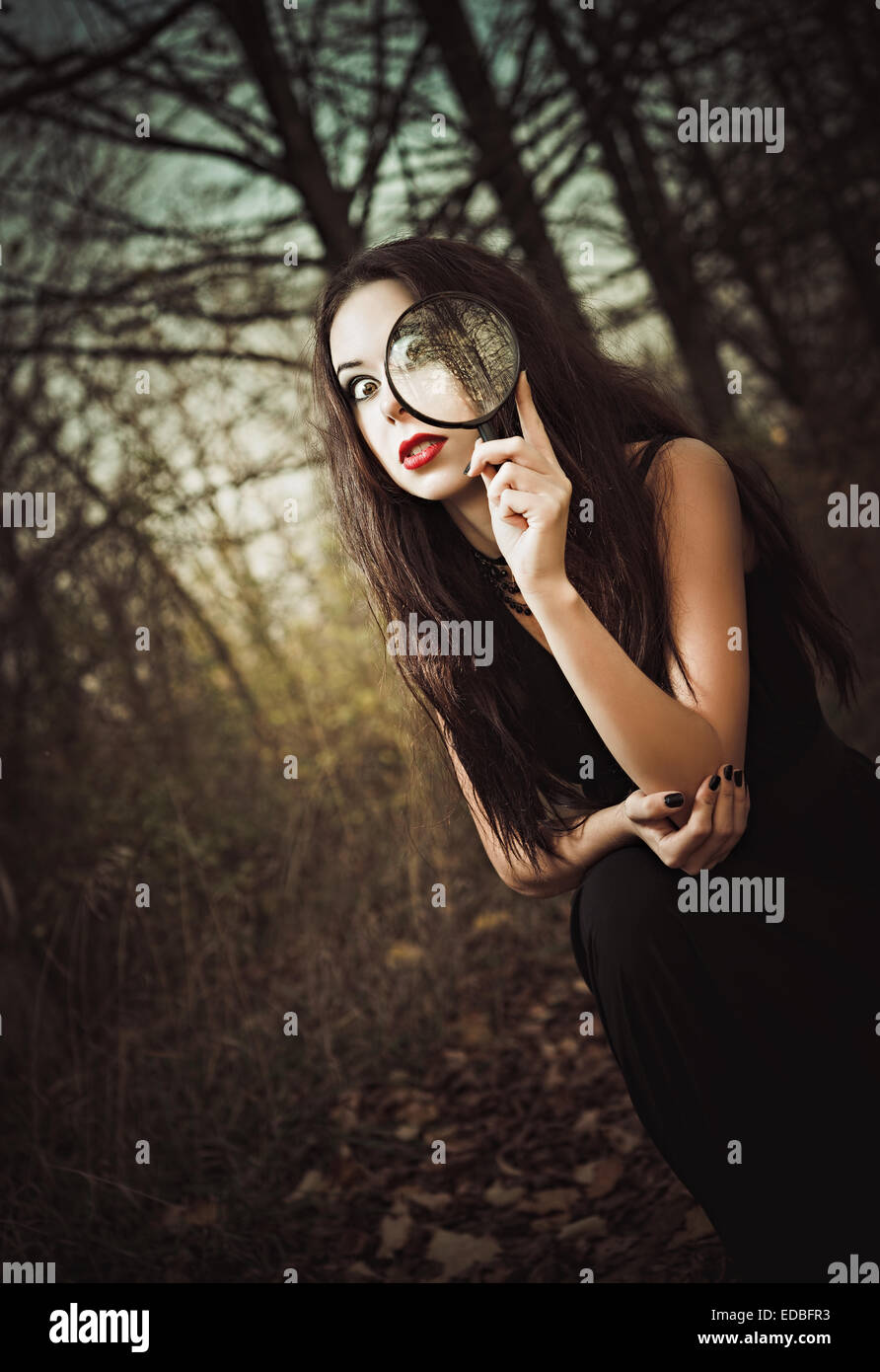 Strange goth girl looks through a loupe Stock Photo - Alamy