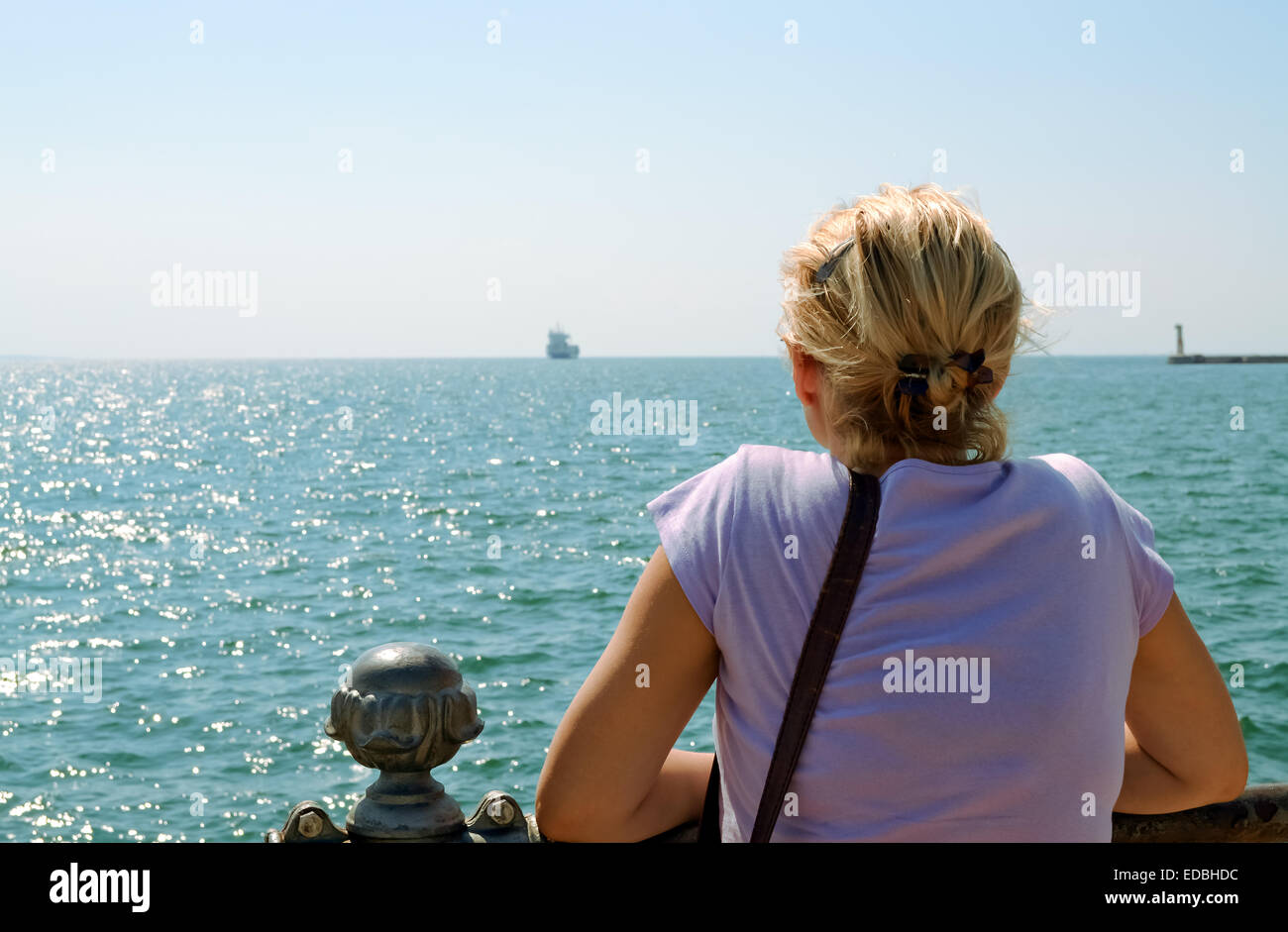 Woman looking at a far away sailed ship Stock Photo - Alamy