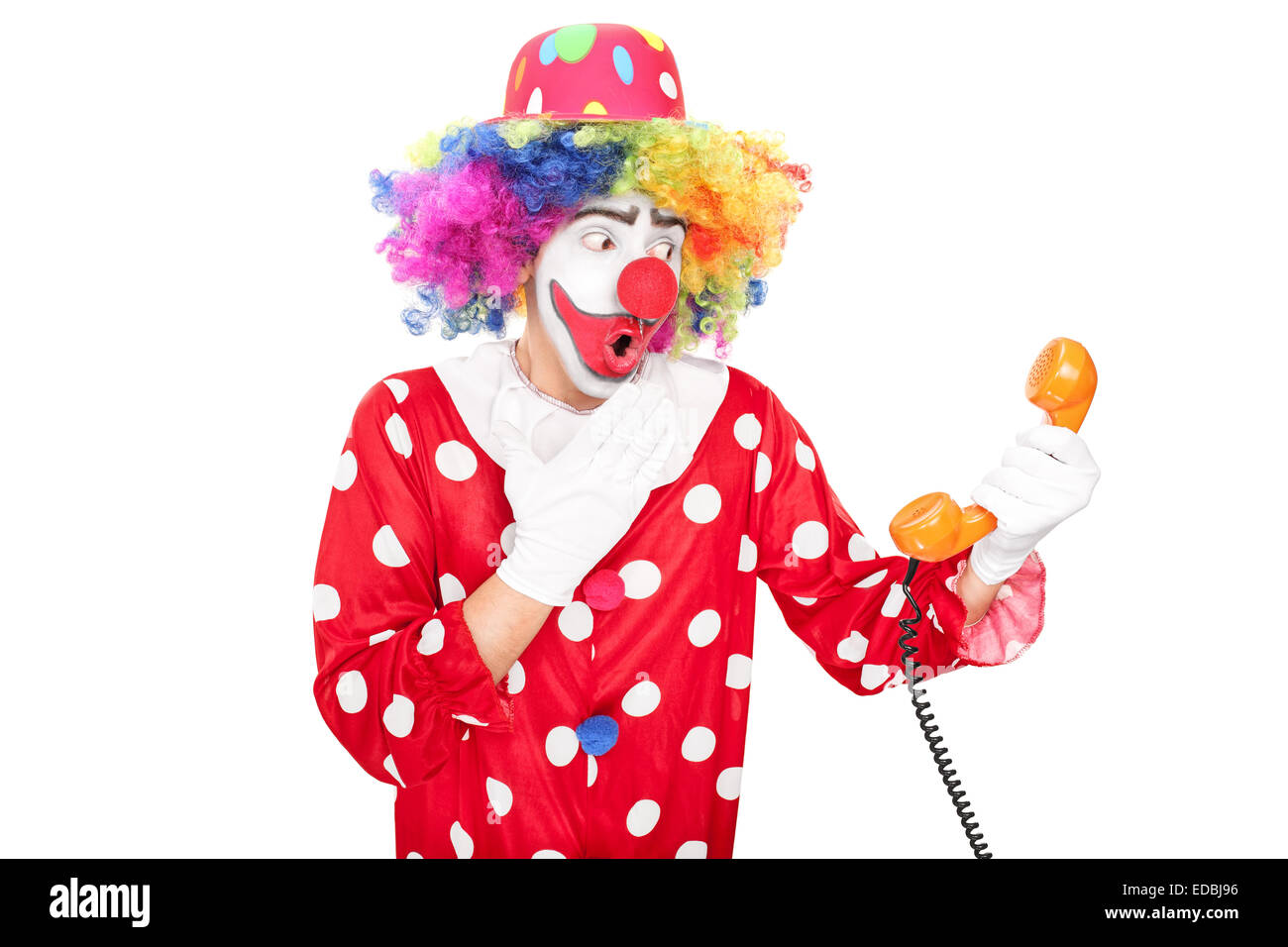Young surprised clown holding a telephone speaker isolated on white ...